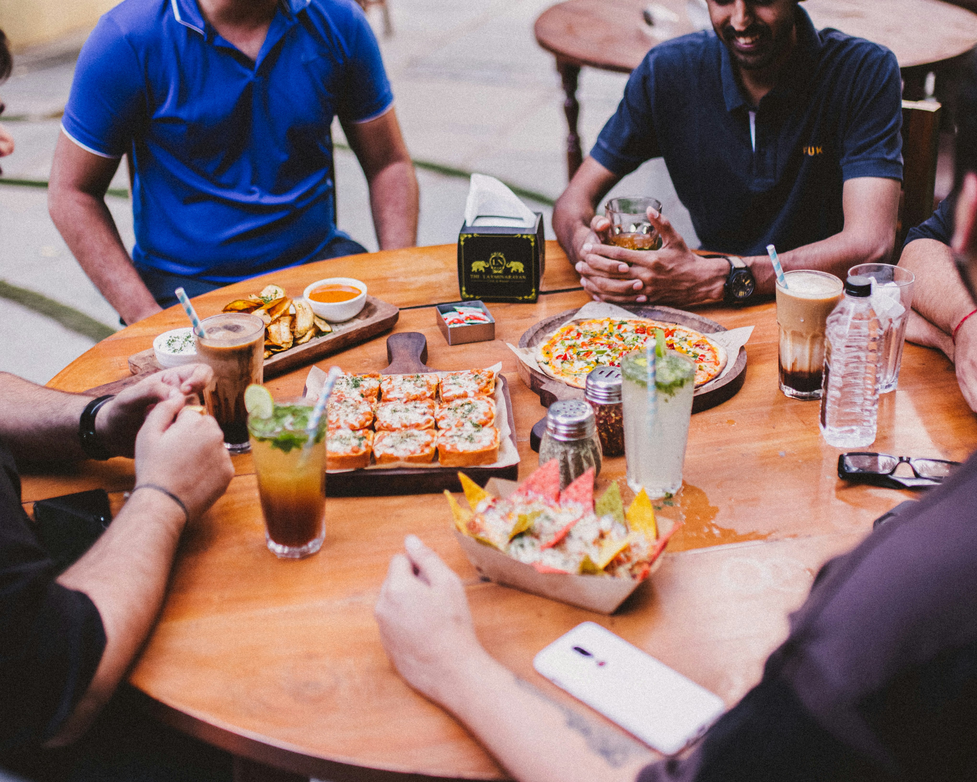 Personnes assises à une table avec des pizzas et des boissons photo ...