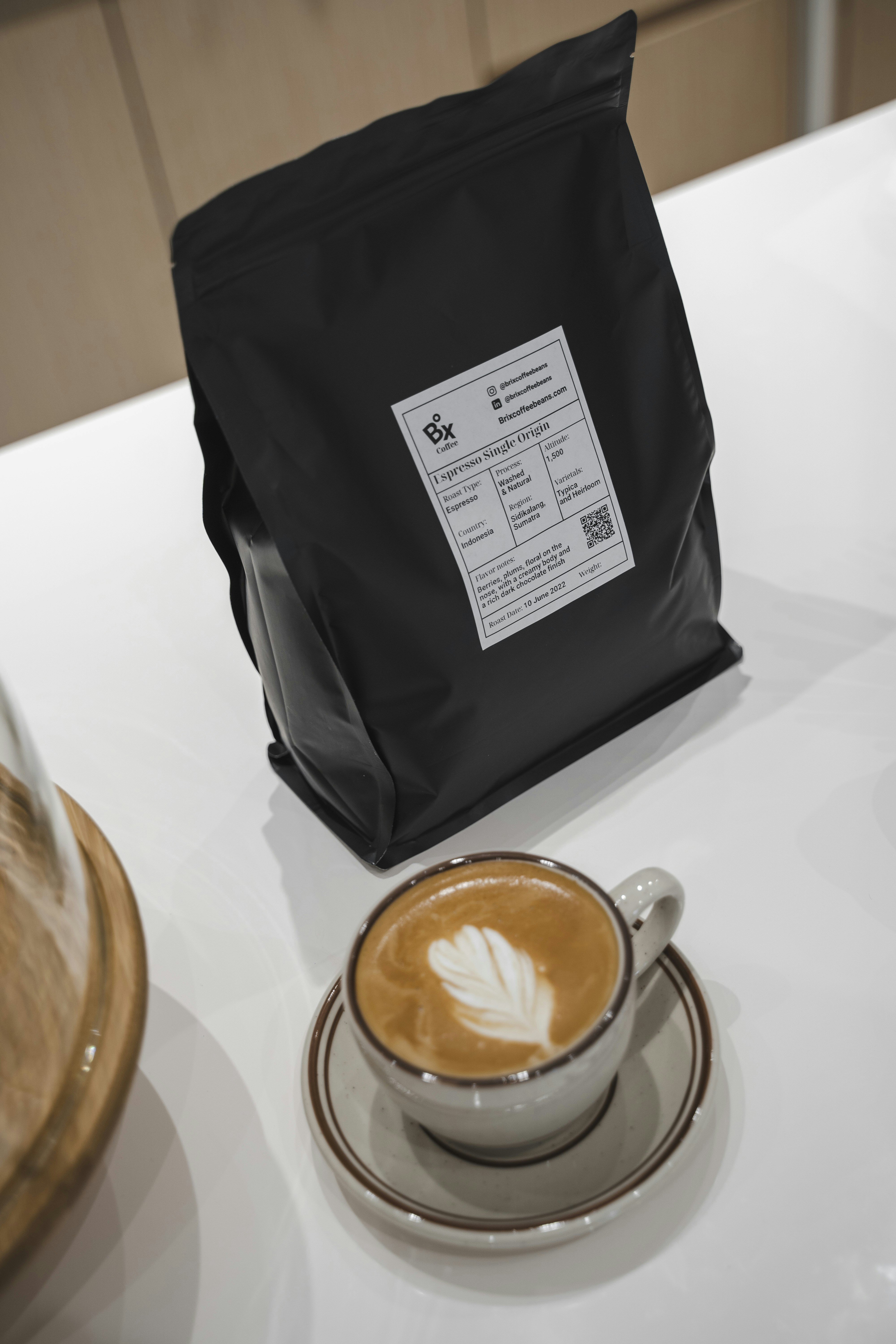 A black bag with a white label and a cup of coffee photo – Free Rae by ...