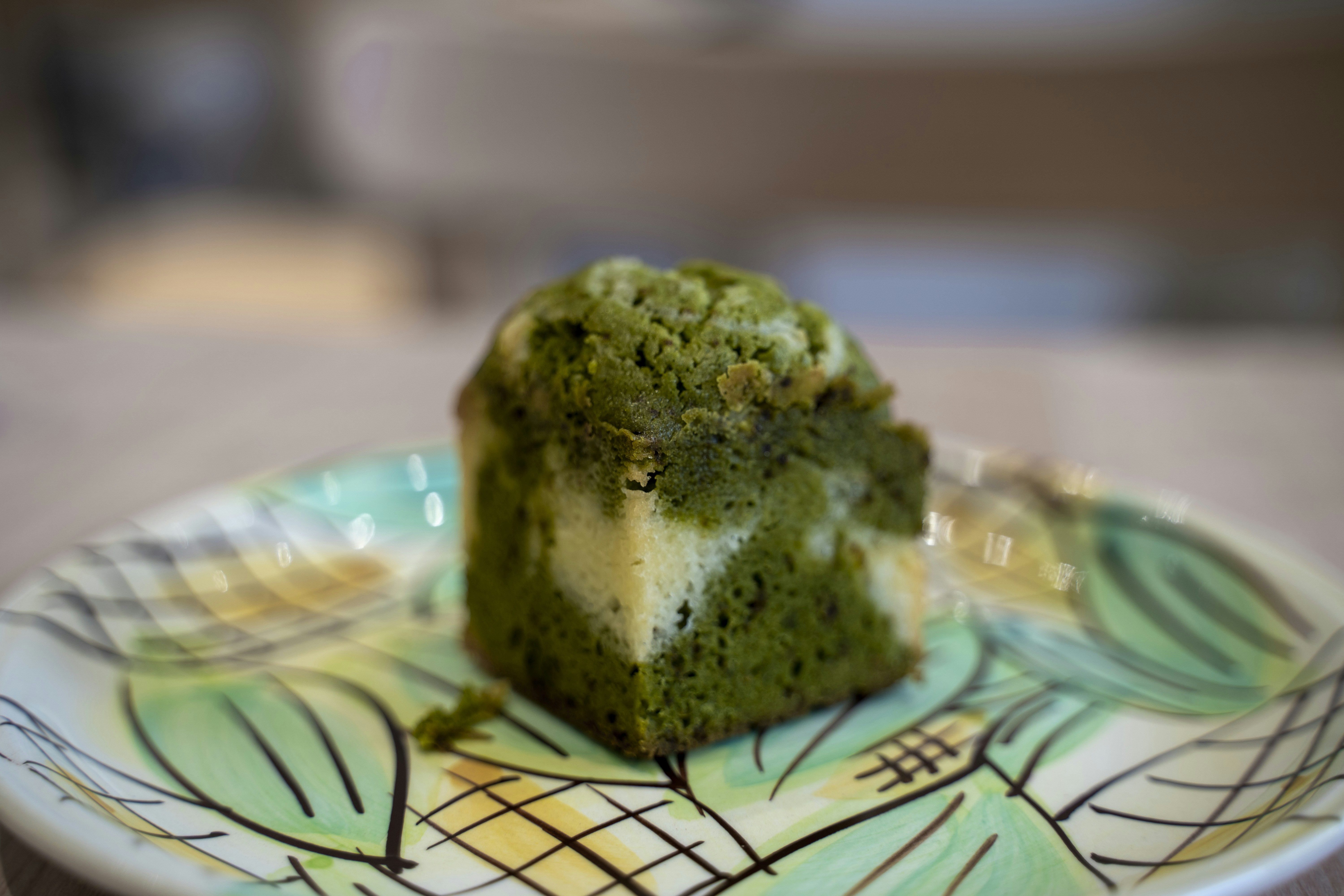Verdant Cube: A Matcha Cake with Cream Core on a Leaf-Patterned Plate