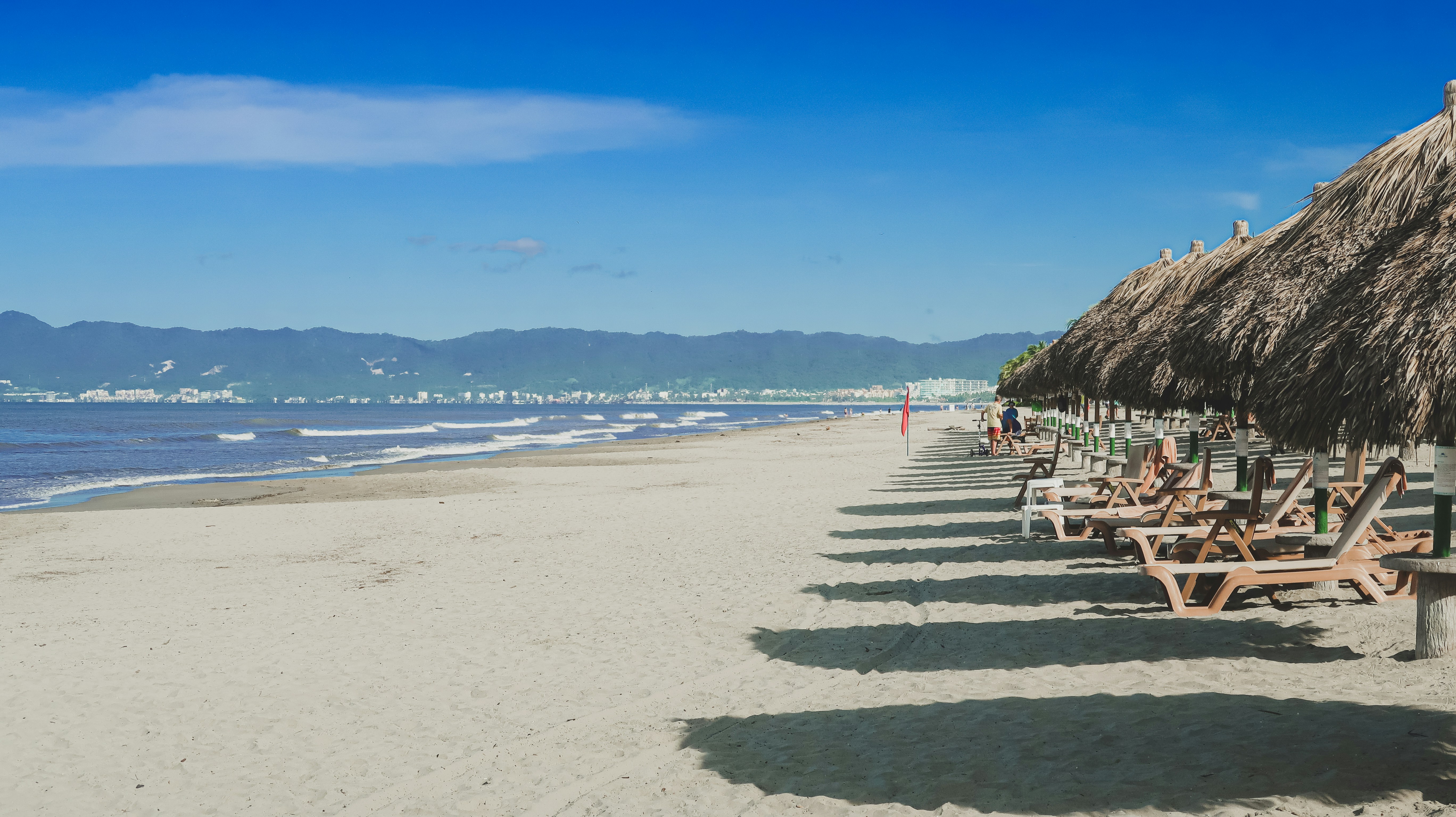 Shoreline Symmetry: Sunlit Beach Chairs Stretching Toward the Sea