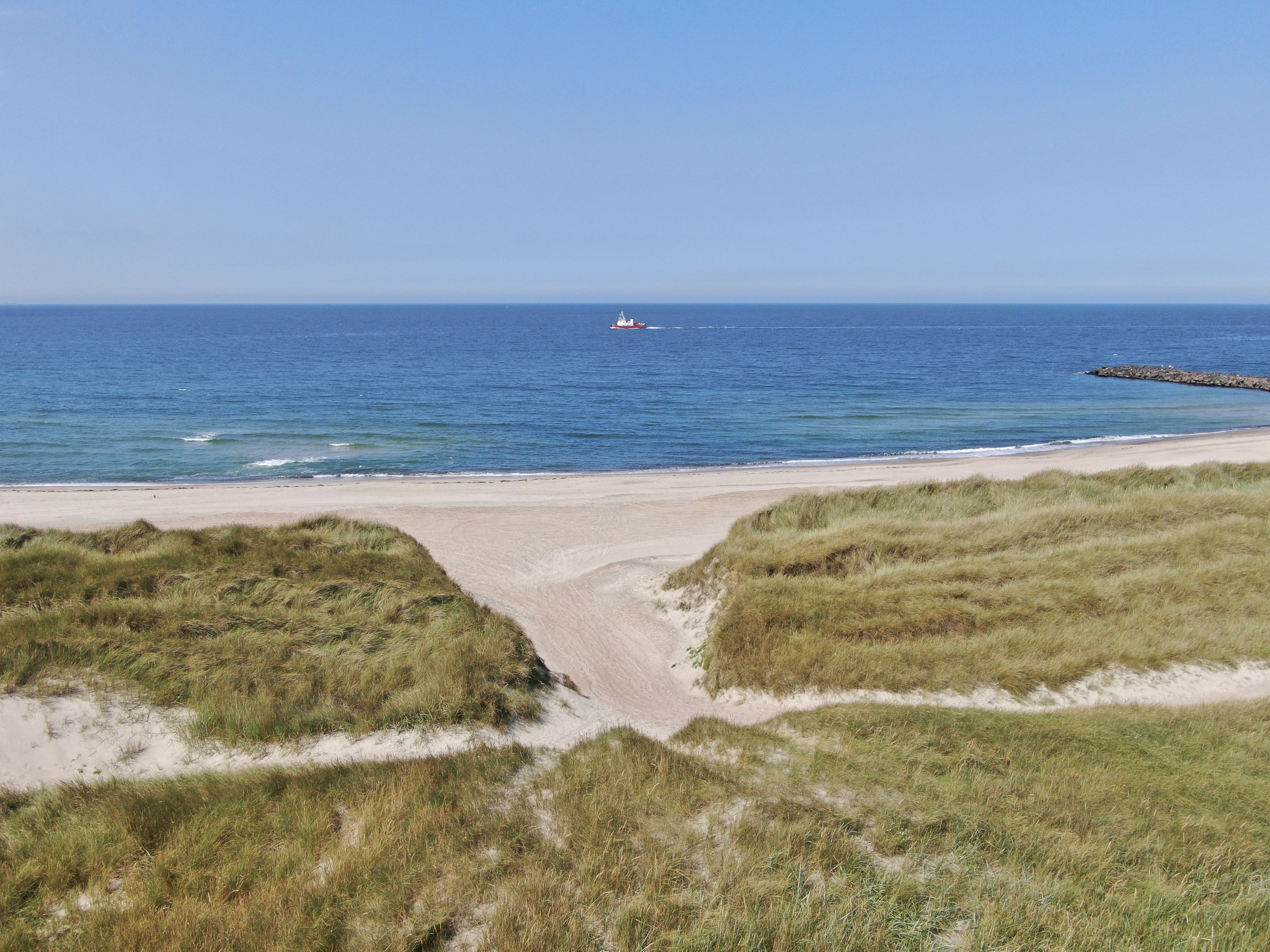 A beach with a boat in the water photo – Free Thyborøn-fæstningen Image ...