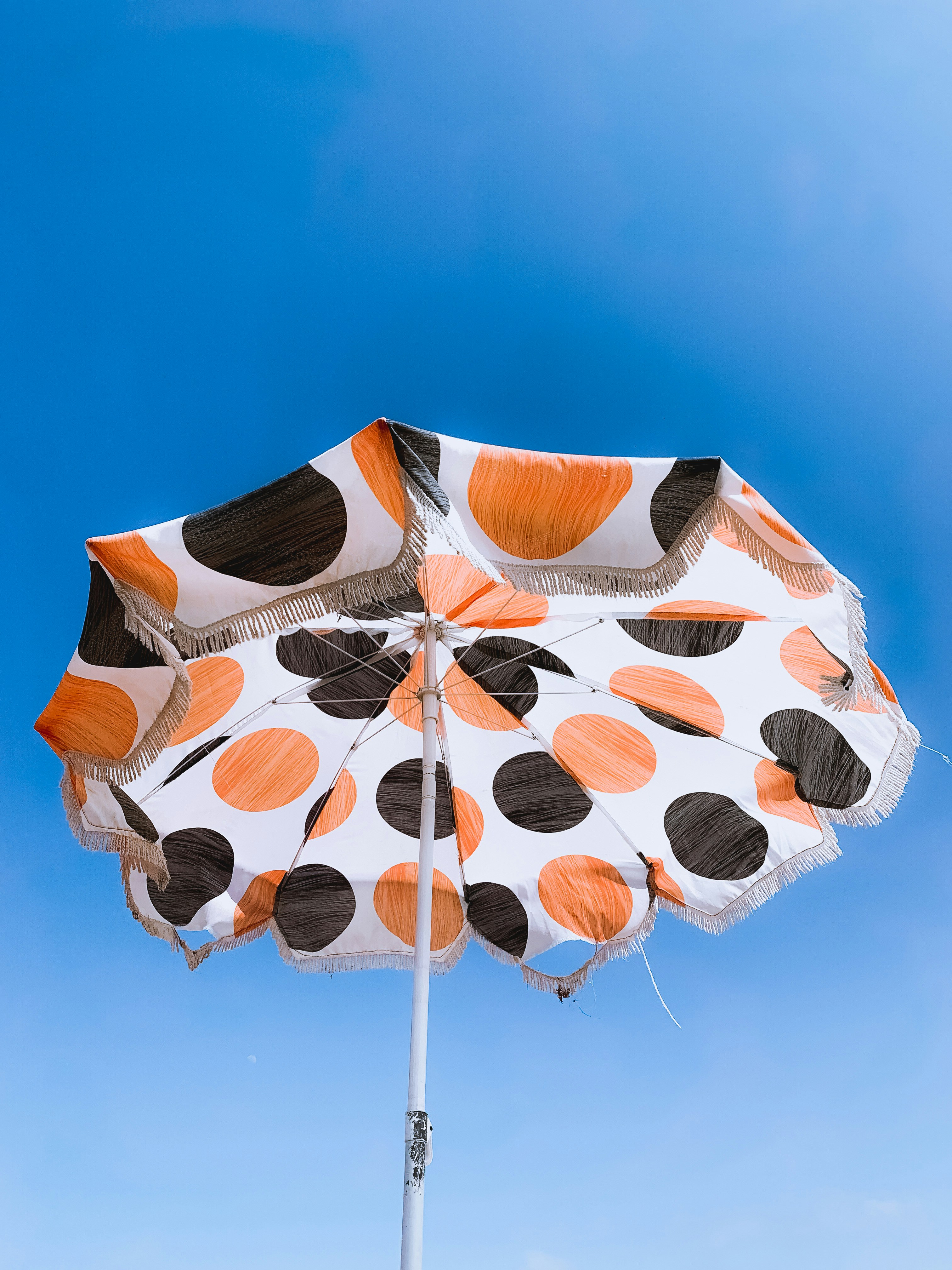 Polka-Dot Umbrella Against a Clear Blue Sky