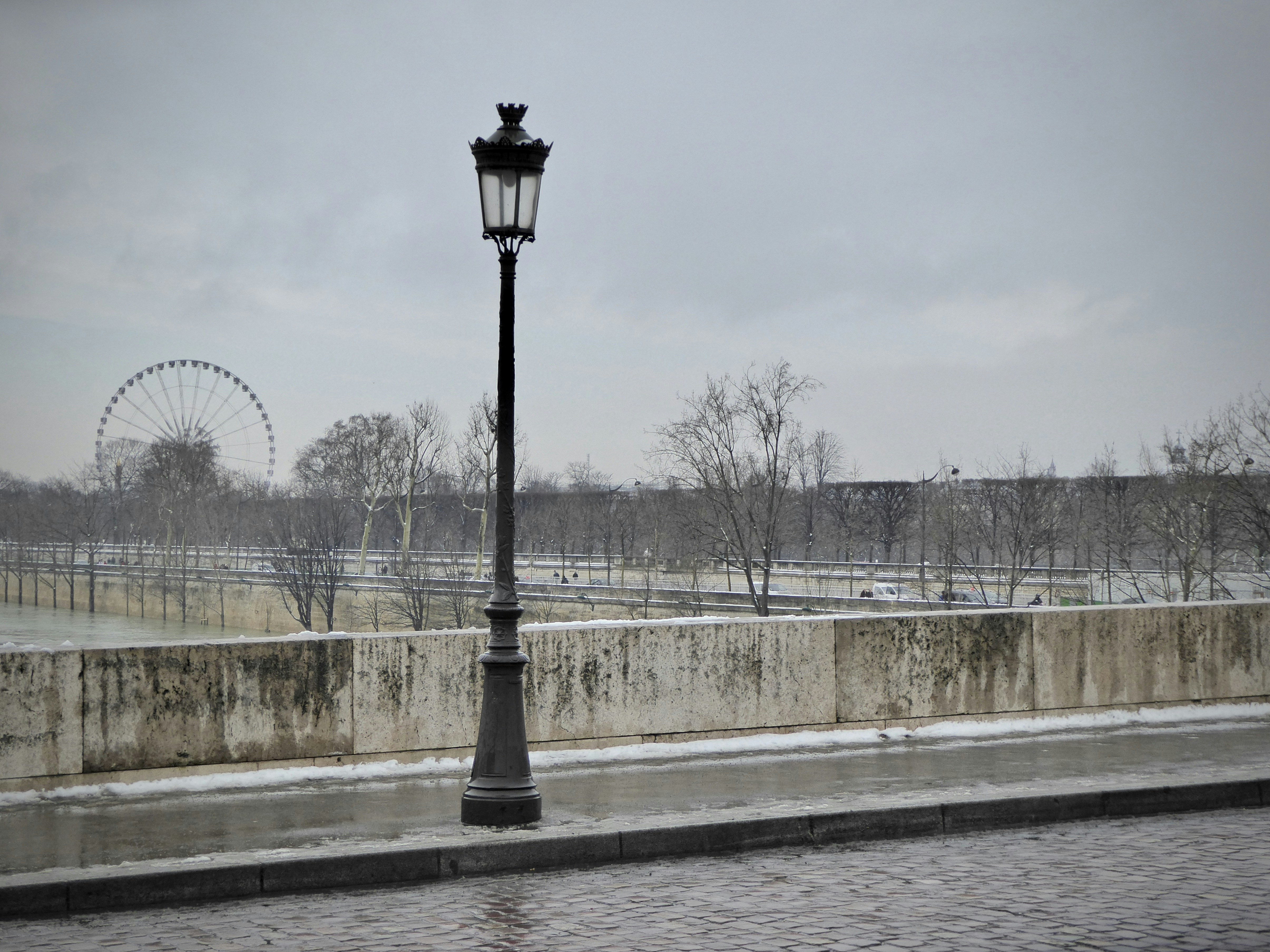 Winter Silence by the Lamppost: A Riverscape with a Distant Ferris Wheel