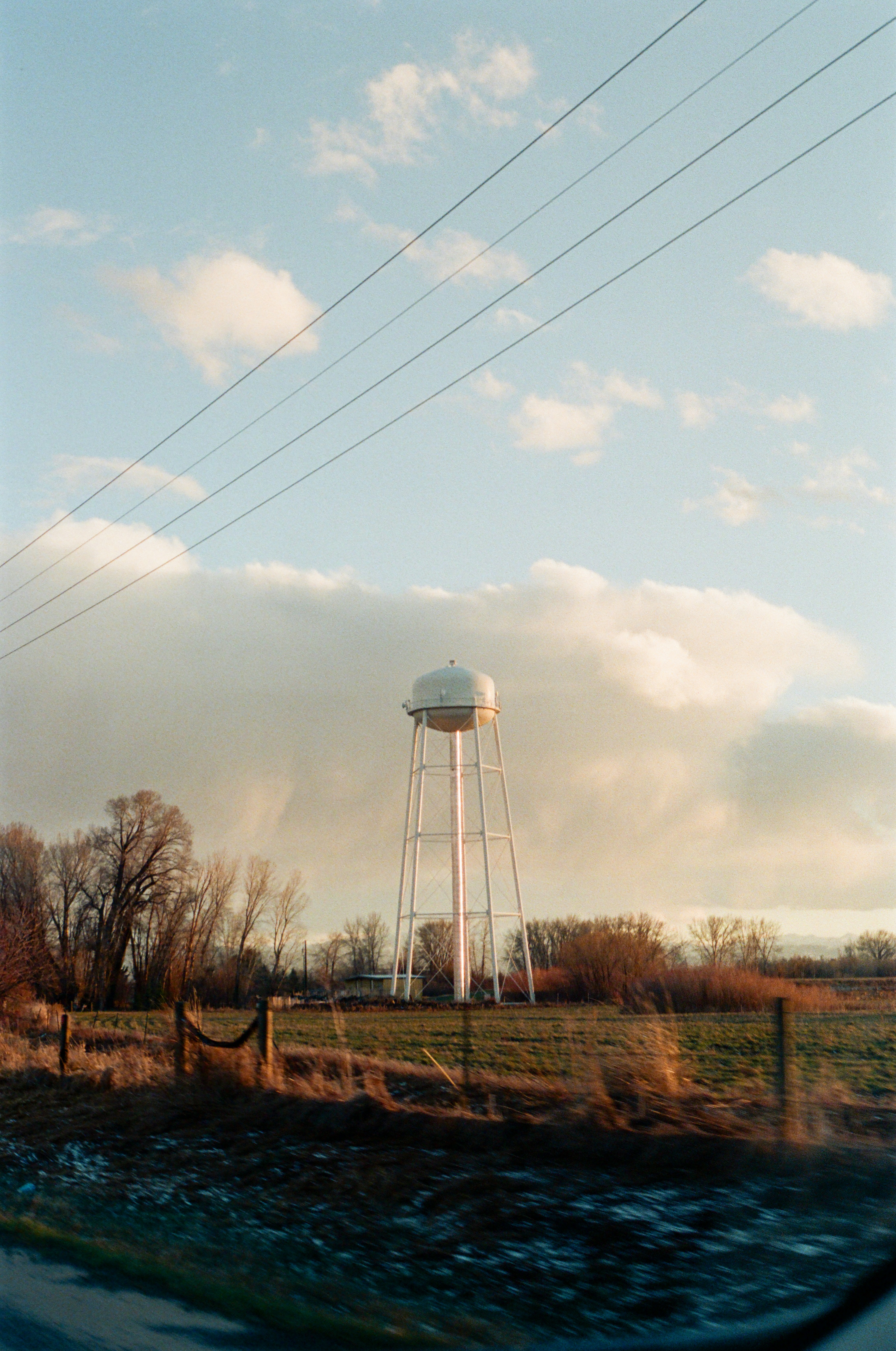 A water tower with trees and a fence around it photo – Free Brown Image ...