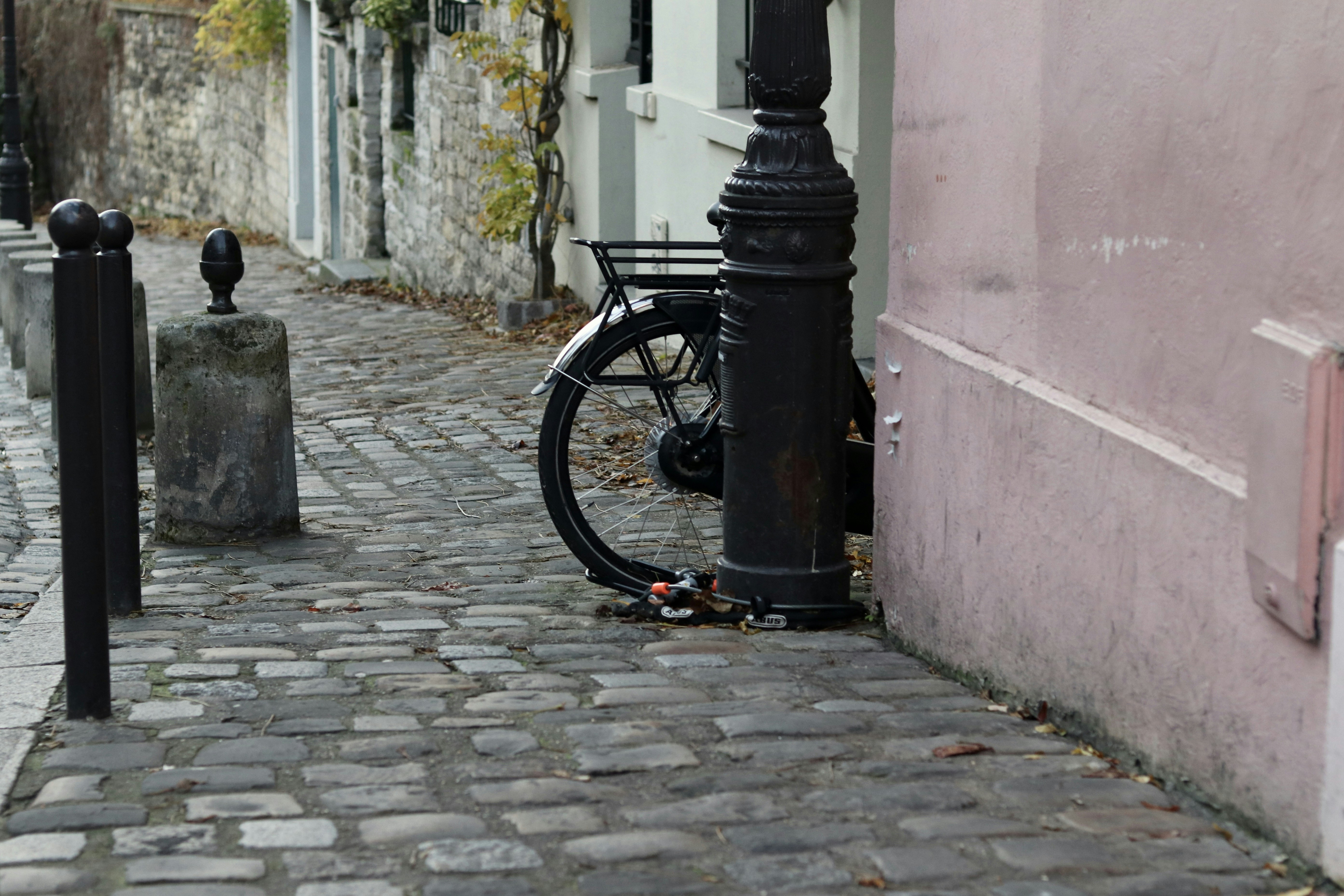 Wheel by the Lamppost on a Cobblestone Alley