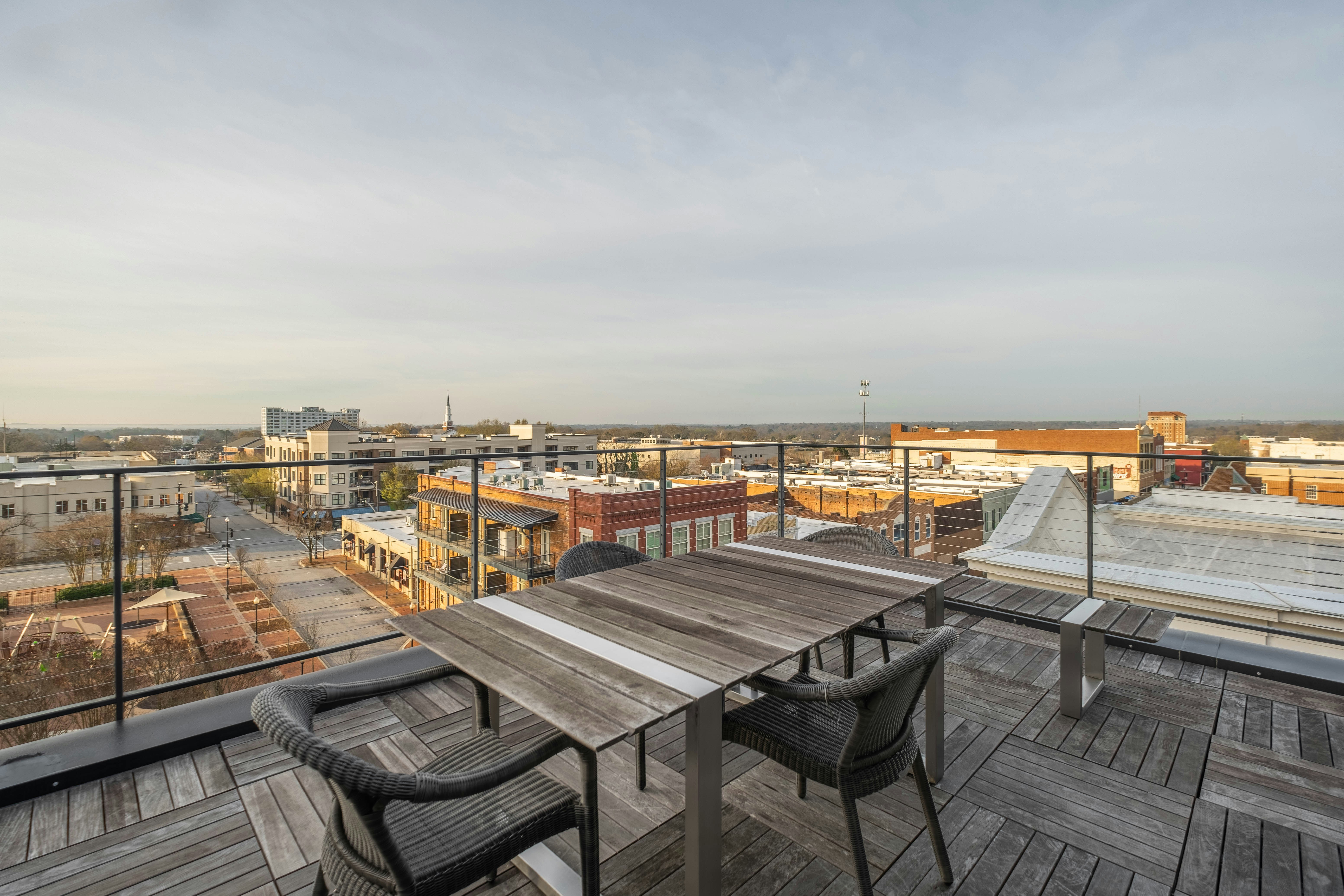 Rooftop Calm: Empty Table Faces the City Horizon