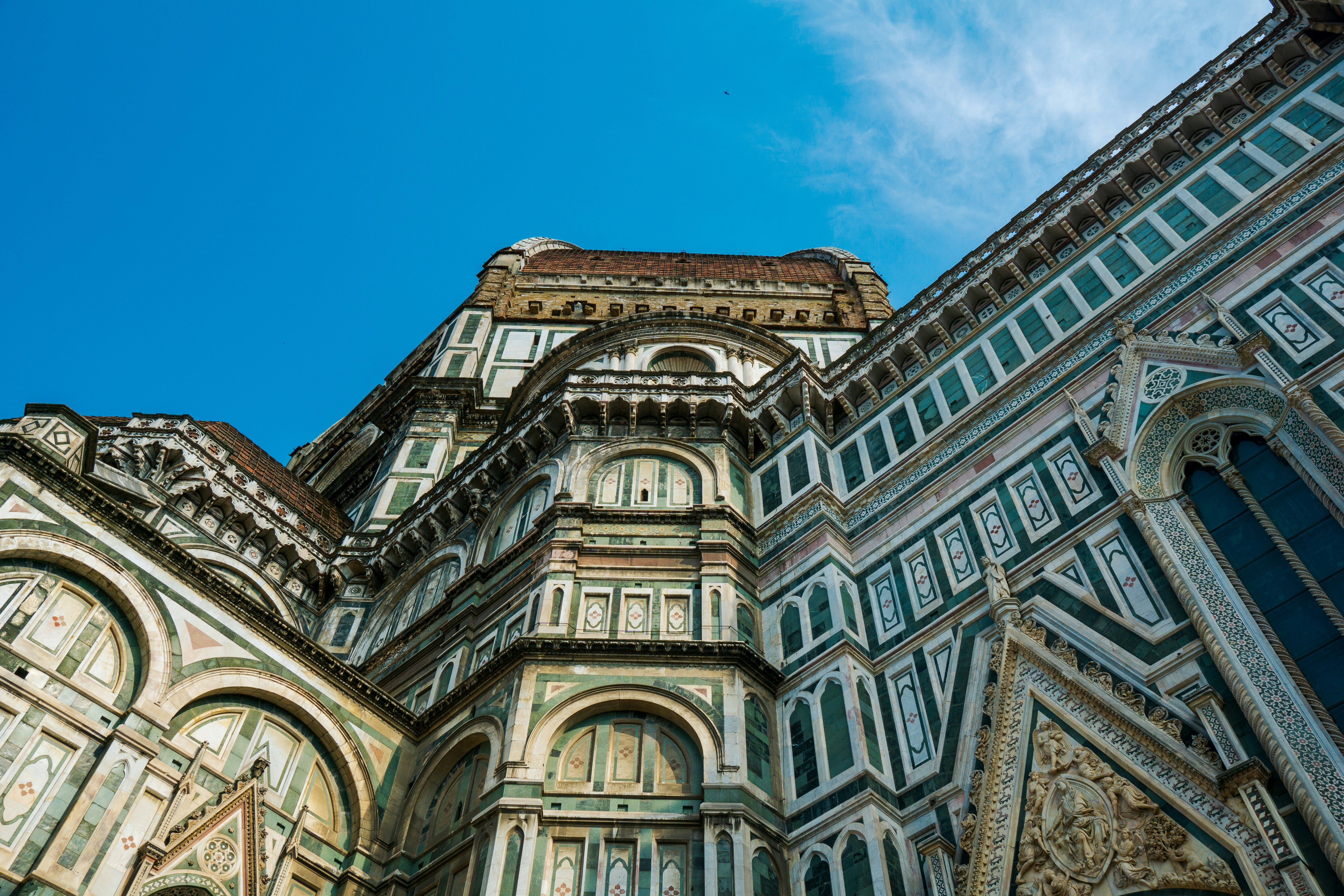 Intricate façade of a historic cathedral showcasing vibrant patterns and detailed sculptures against a clear blue sky.