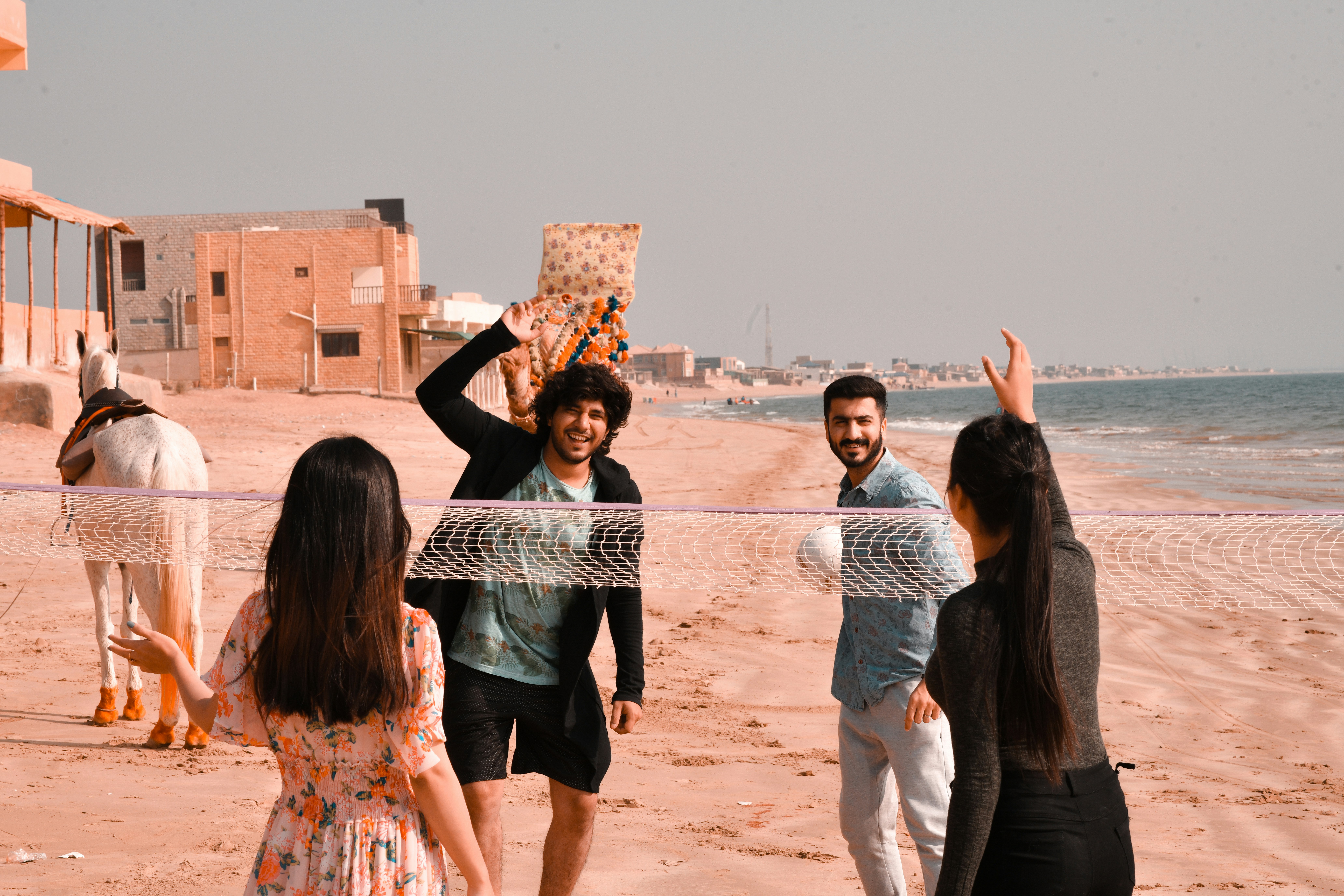 Beachside High Five: Friends Cheer as Net Teammates Celebrate