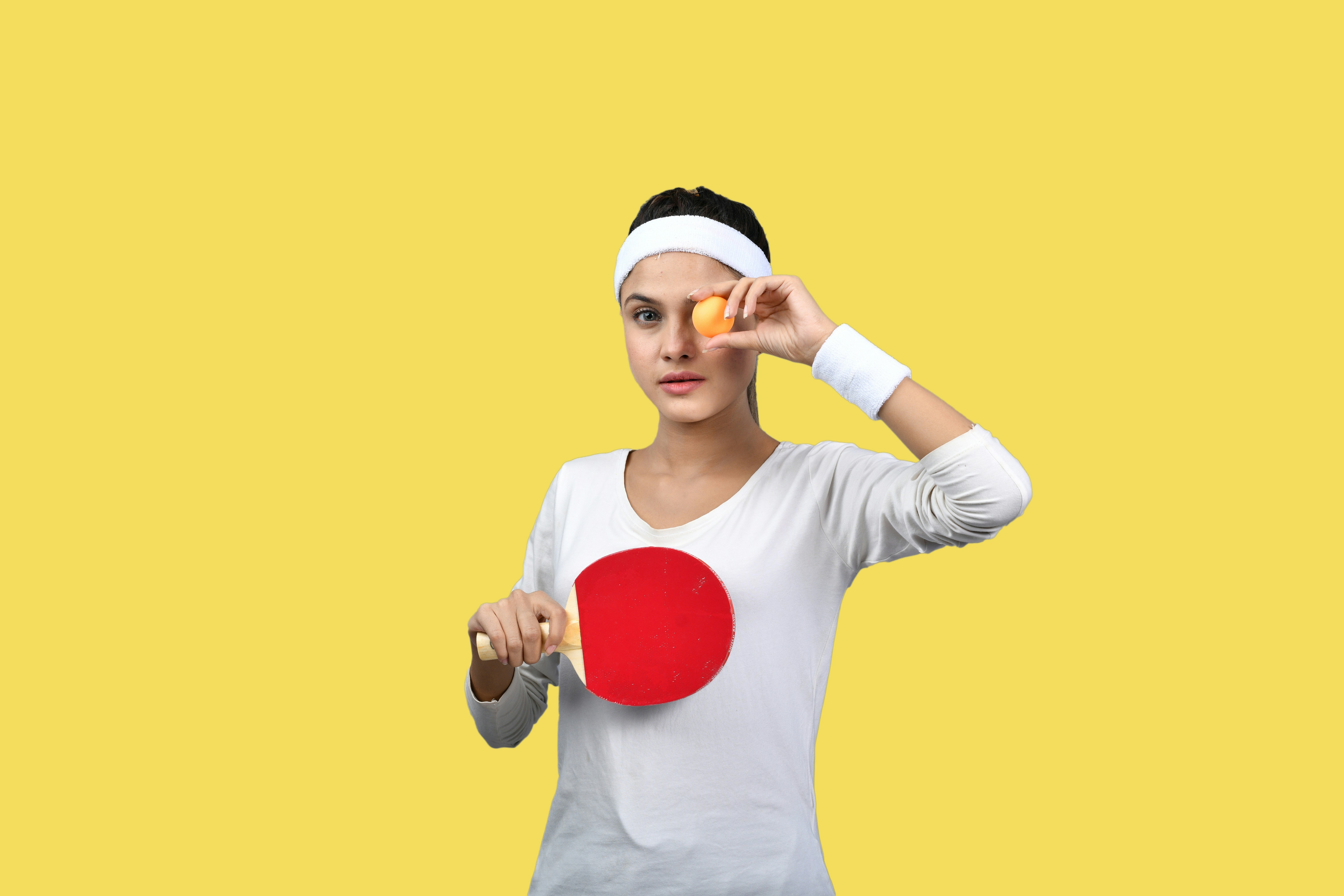 Yellow Backdrop, White Shirt, and a Red Ping-Pong Disc: A Minimal Table-Tennis Moment