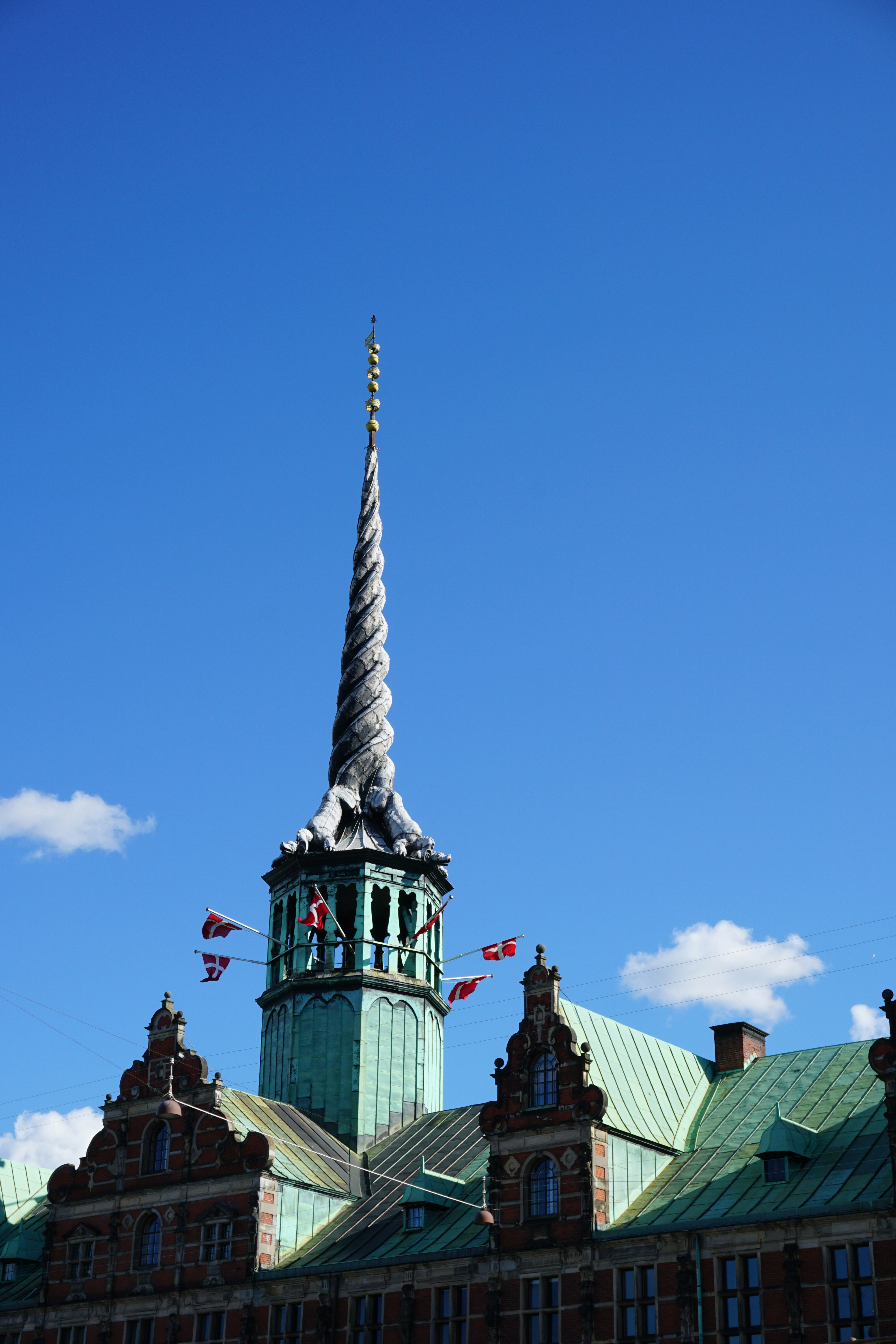 A tall pointy tower with flags photo – Free Spire Image on Unsplash