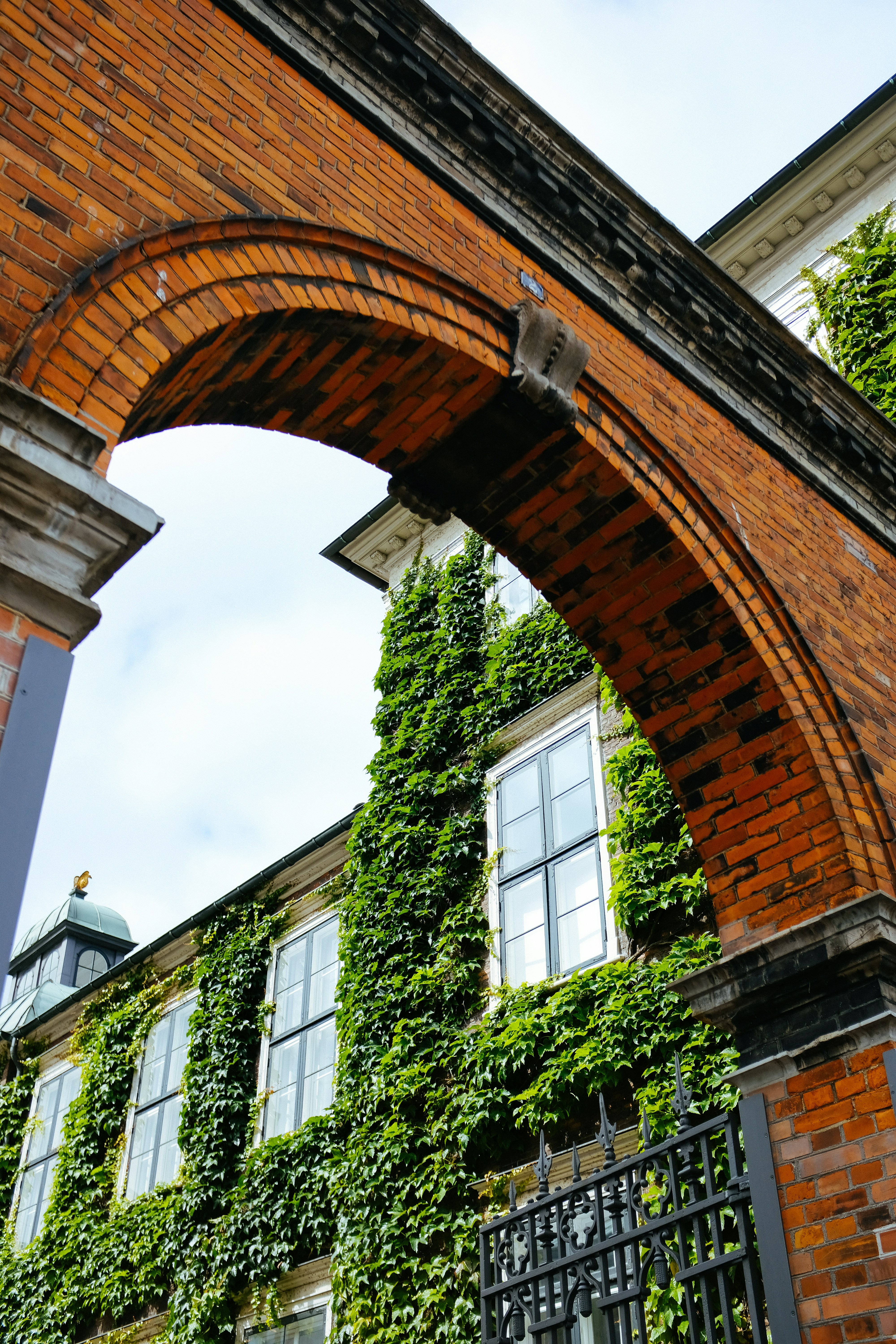 Ivy-Draped Archway Framing a Historic Facade