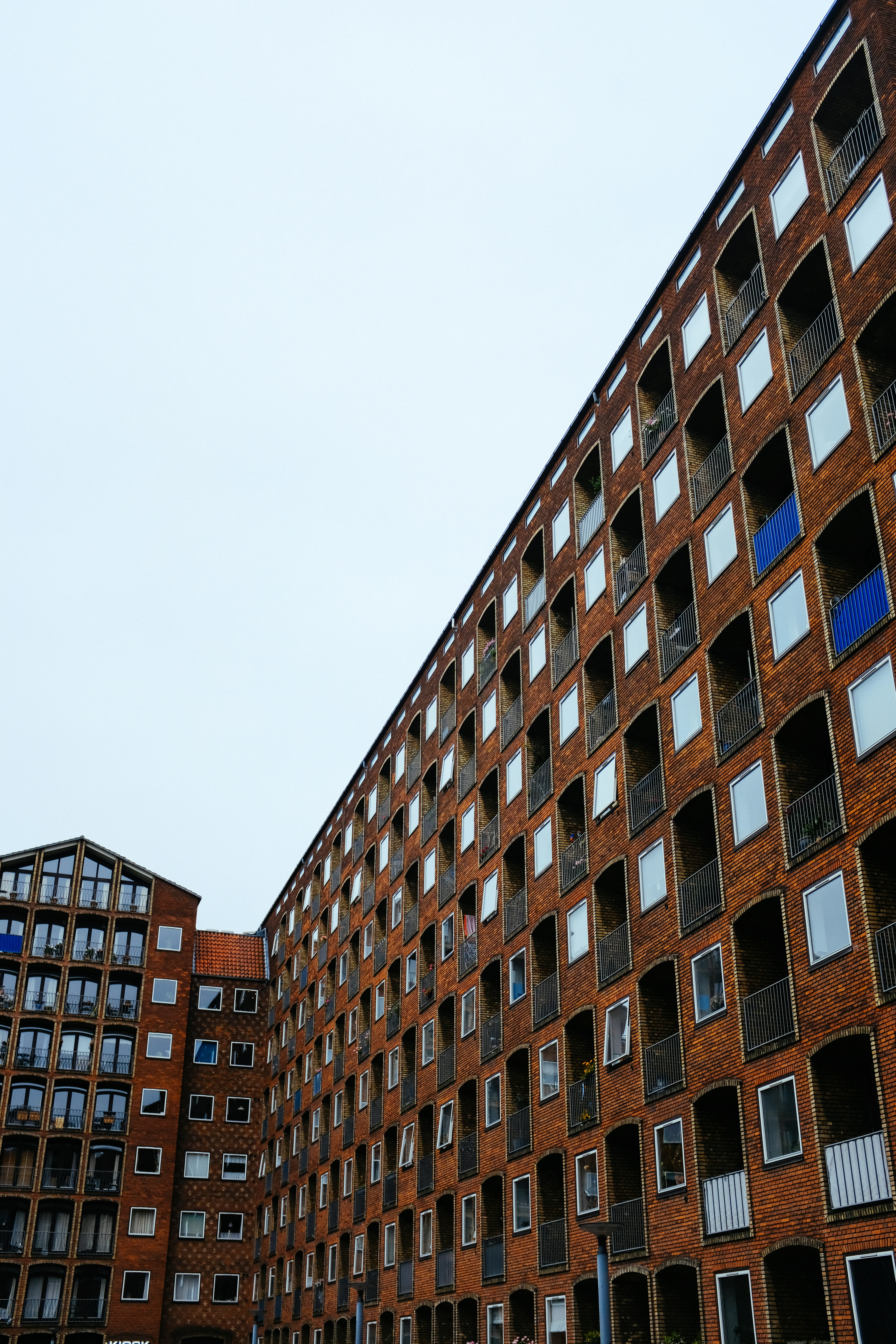 Architectural facade featuring a grid of windows and balconies in a residential building, showcasing modern urban design.
