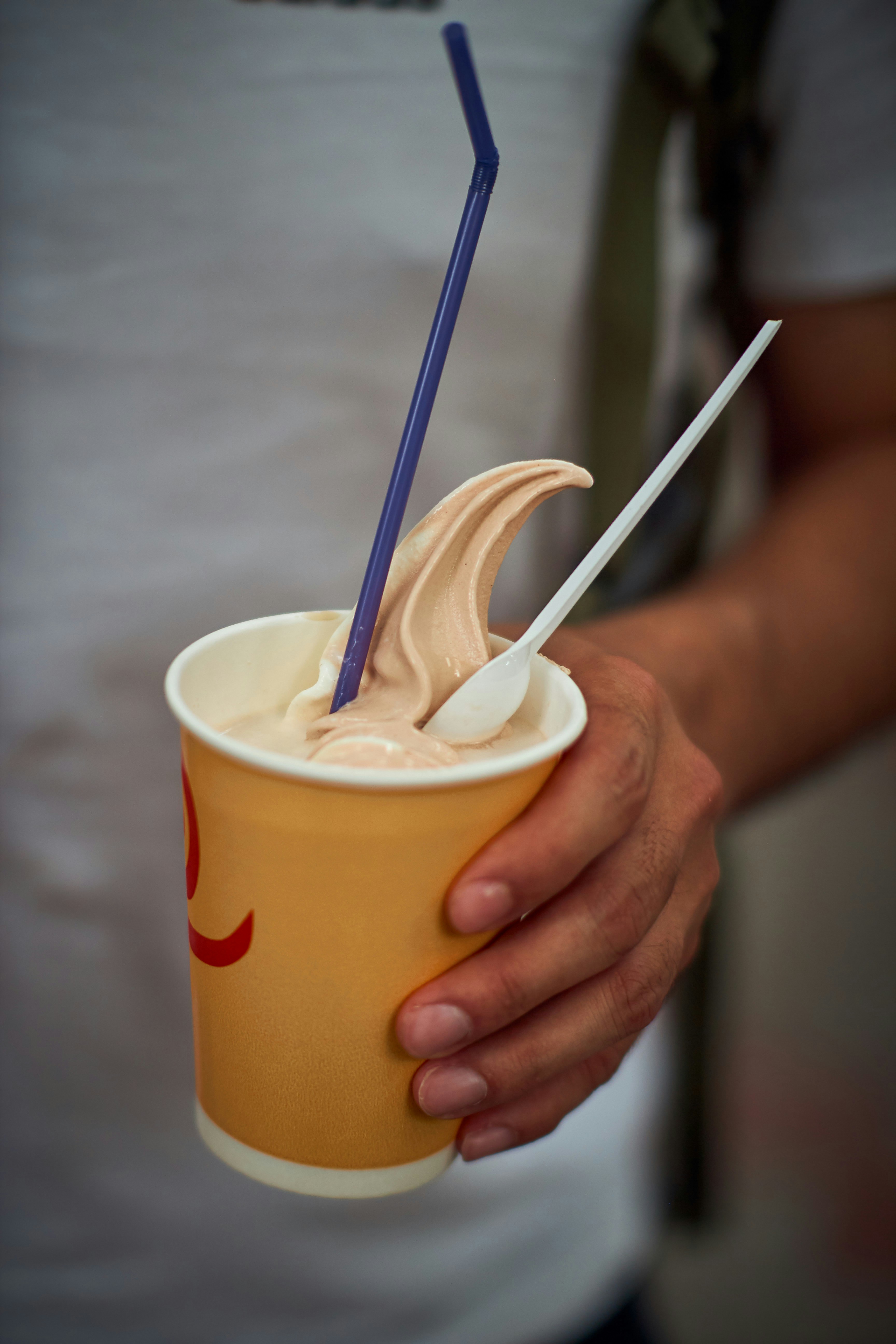 Hand-Held Vanilla Swirl: a sunlit cup gripped mid-sip with two straws