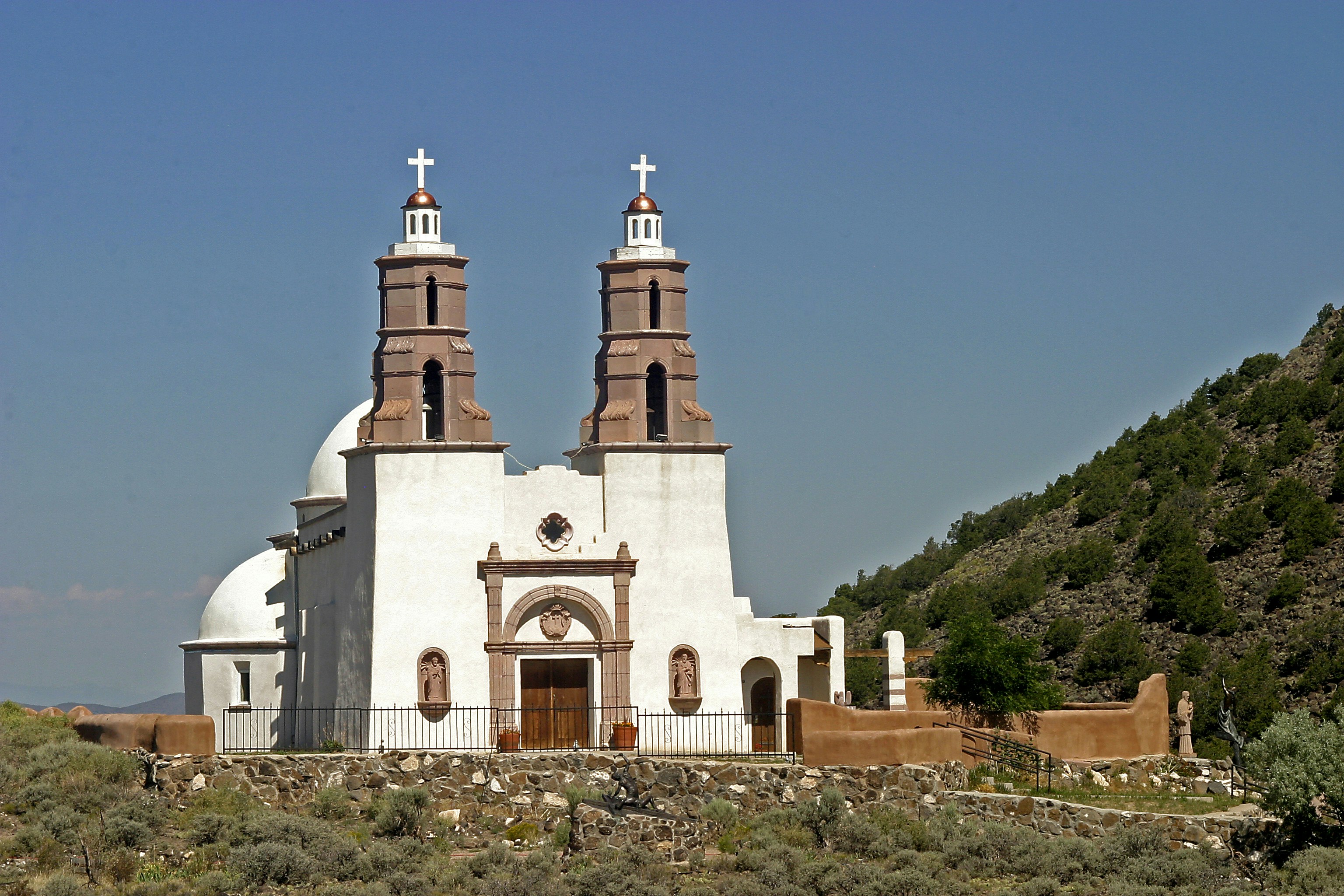 Stations of the Cross Shrine in San Luis, CO | a white building with a cross on top