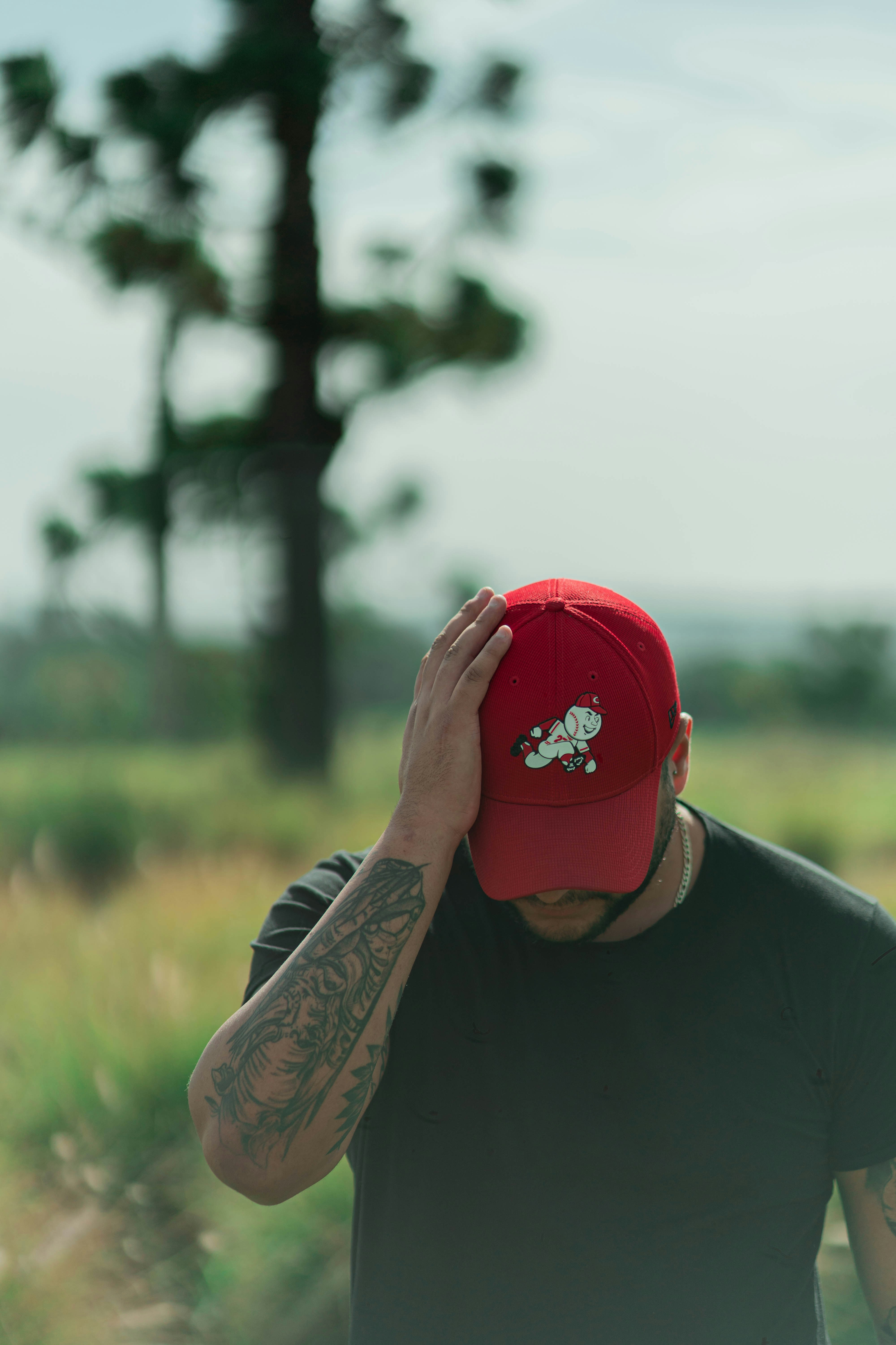 a man with a hat and a tattoo on his arm