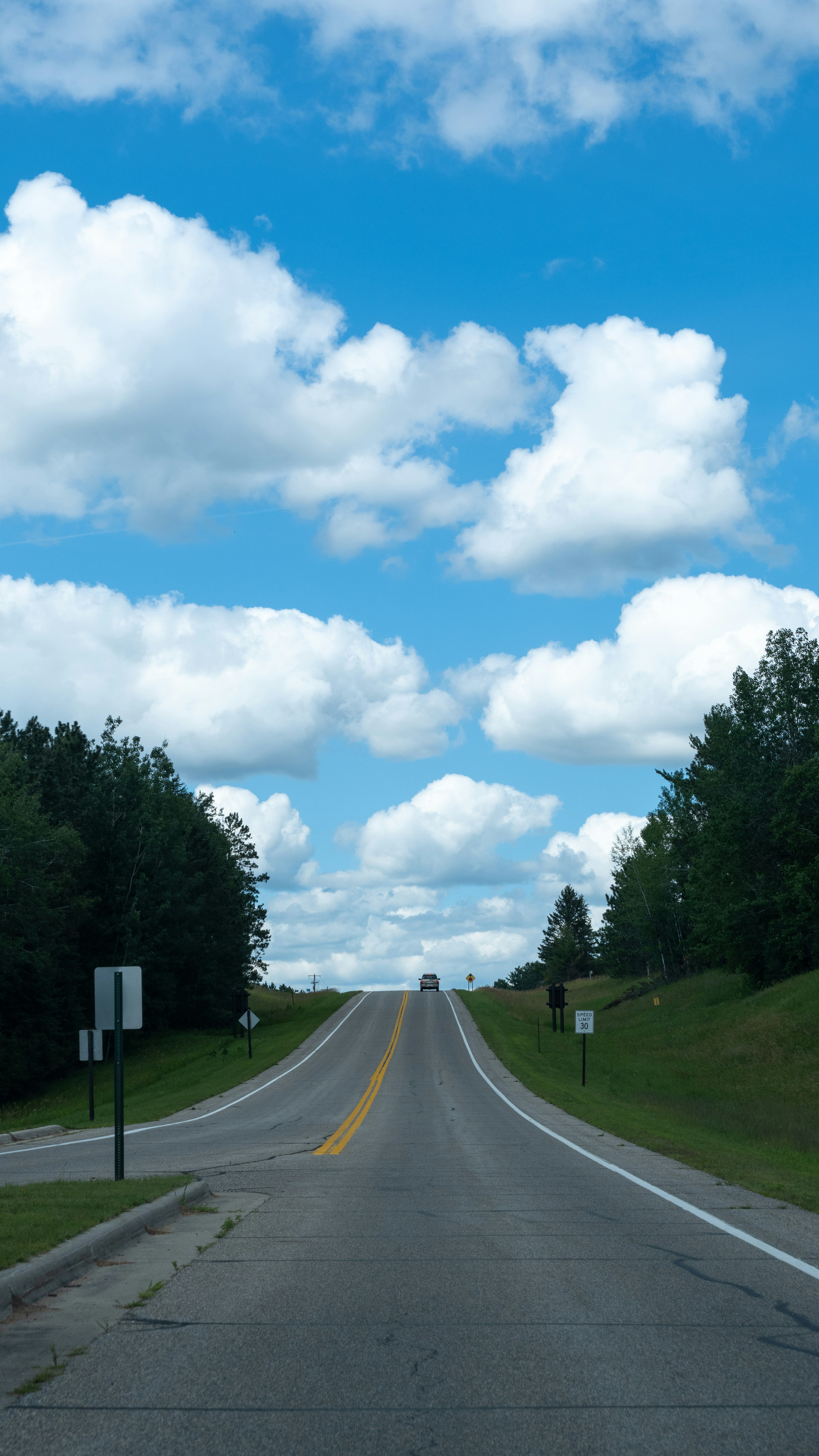 a road with trees and grass on the side