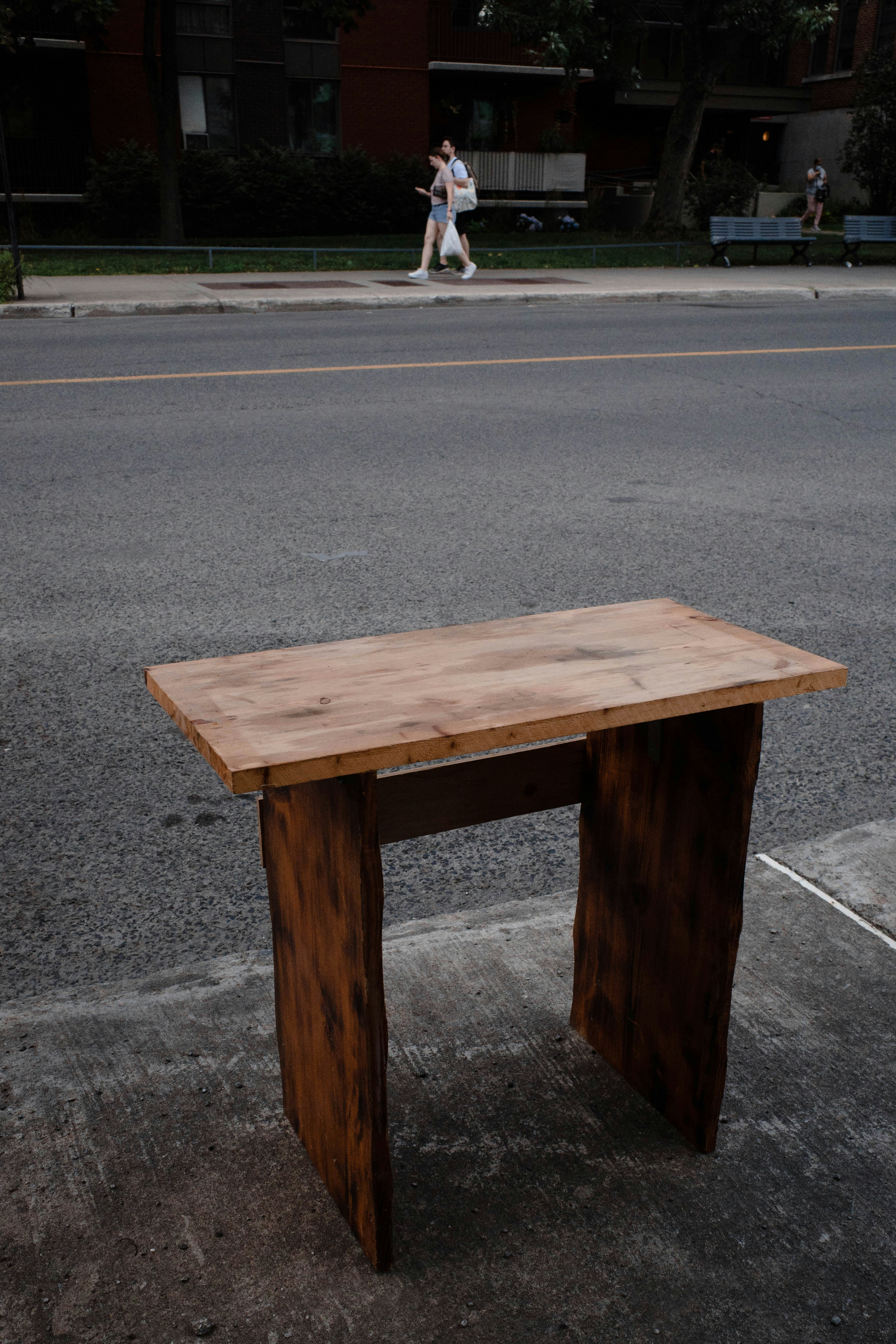 Edge of Utility: A Weathered Table Anchoring a City Sidewalk