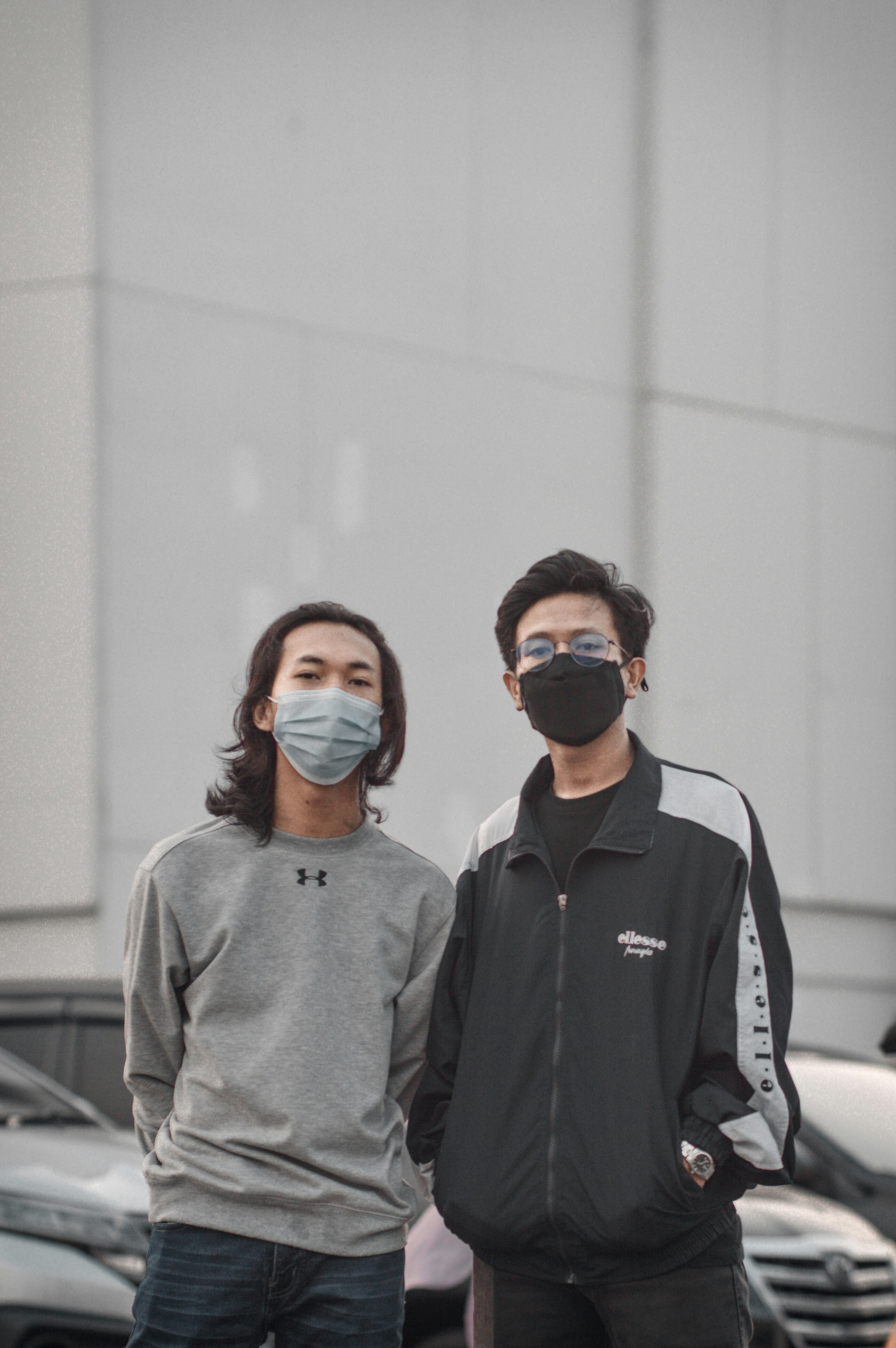 Two Friends in Masks by a Modern Urban Wall