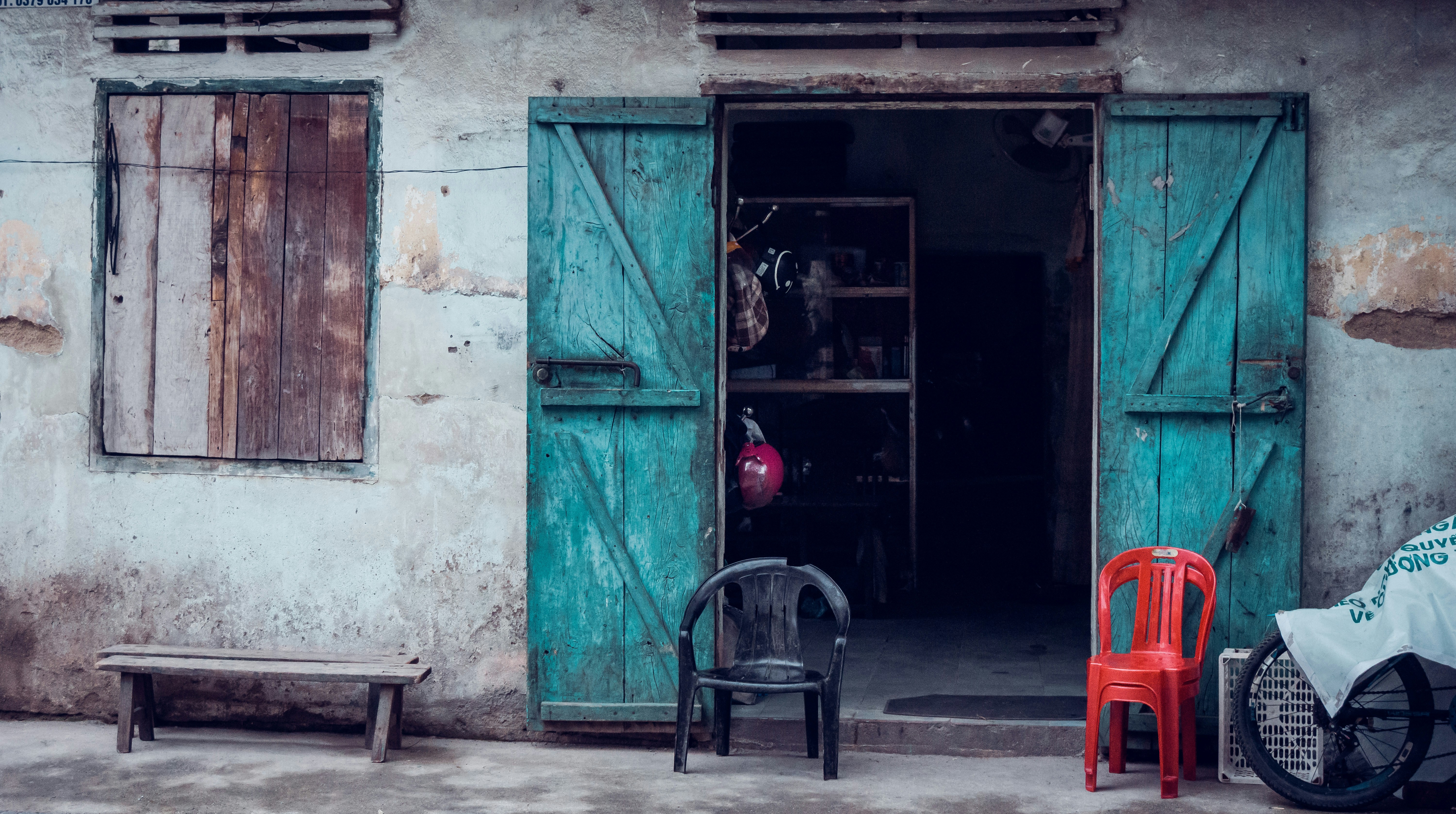 A couple of chairs sit outside of a building photo – Free Image on Unsplash