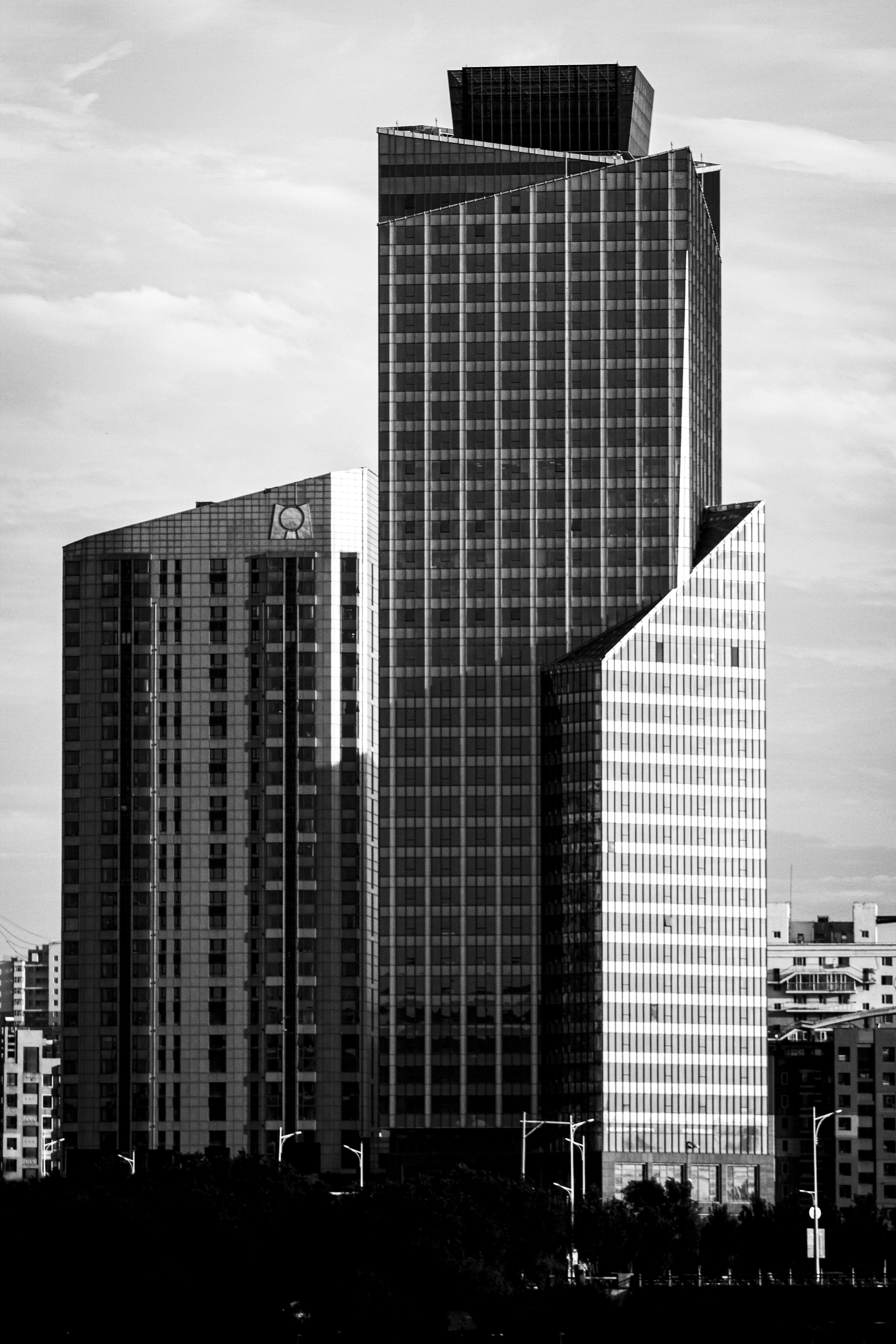 Foto Un par de edificios altos – Imagen Edificio B&W gratis en Unsplash