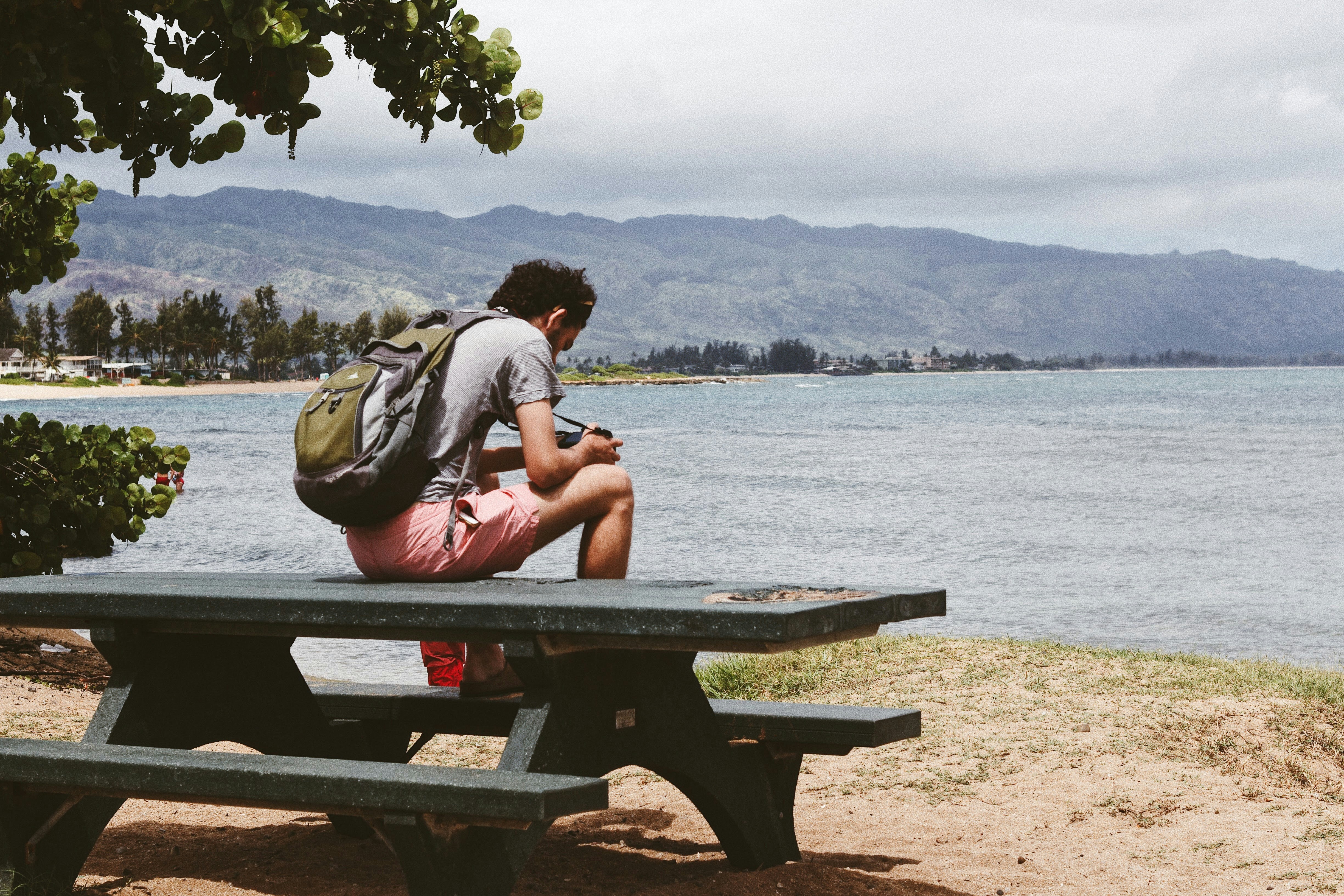 a person sitting on a bench in front of a body of water