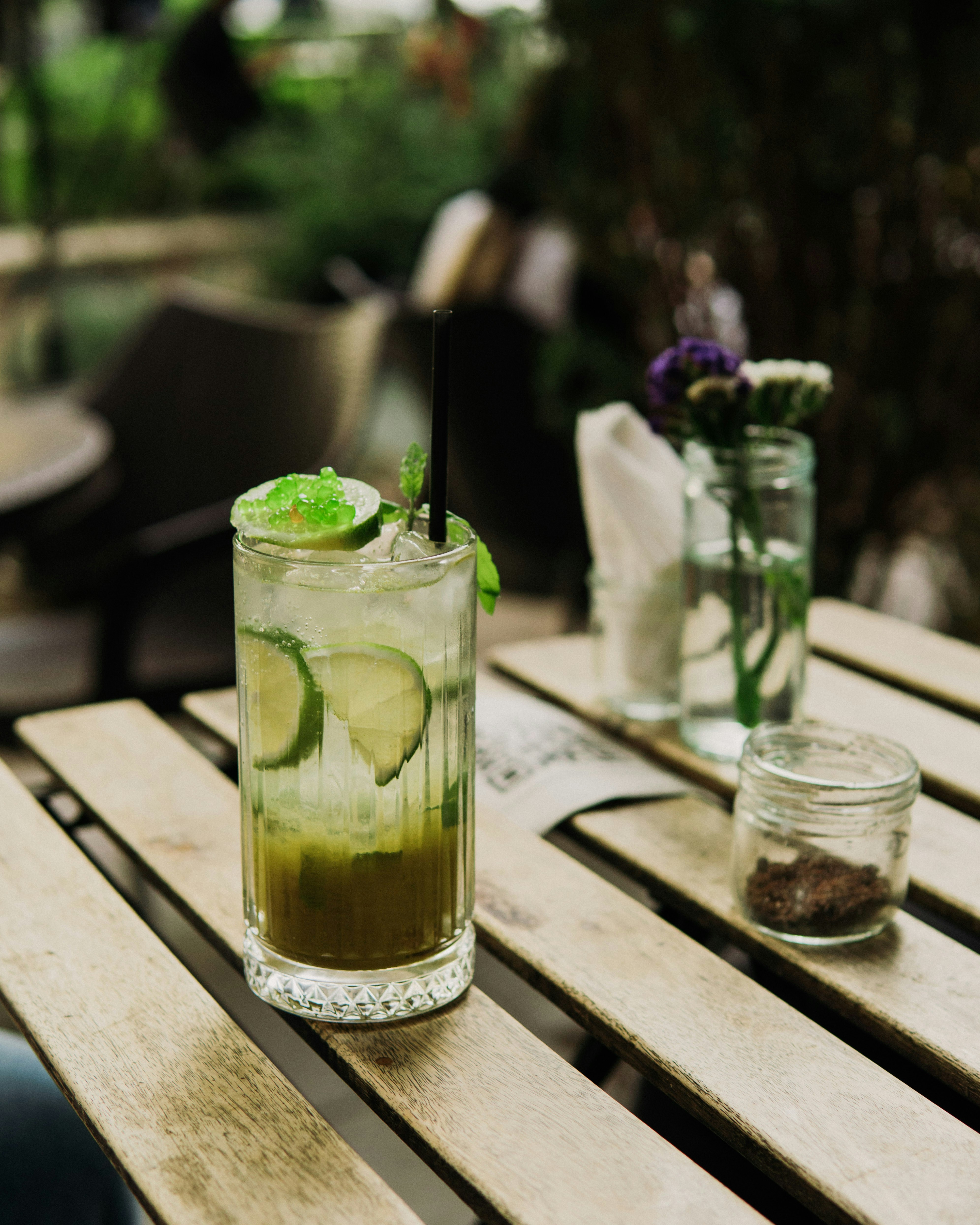 Mojito on a Sunlit Patio: Lime, Mint, and a Rustic Wooden Table