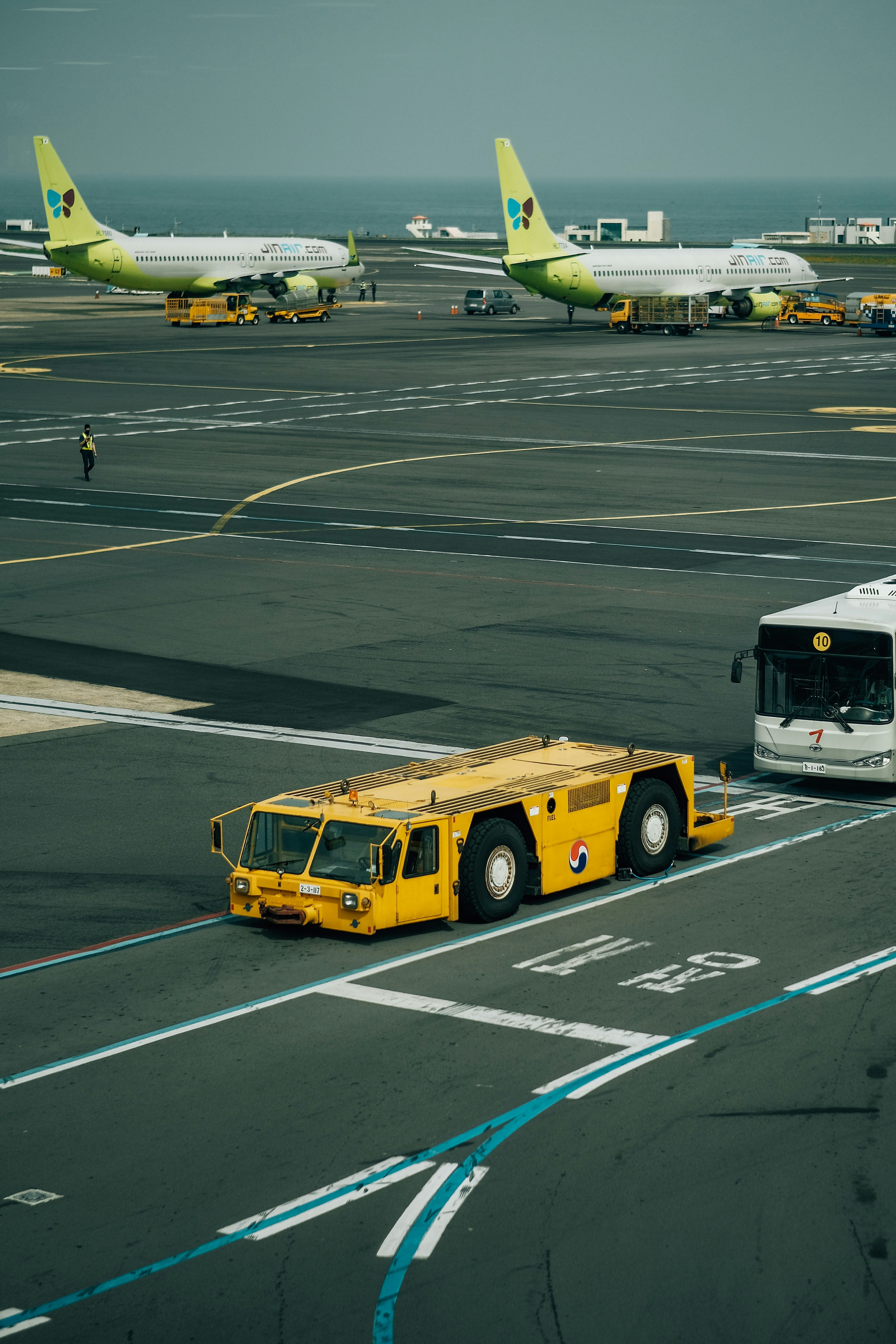 a yellow truck parked in front of an airplane