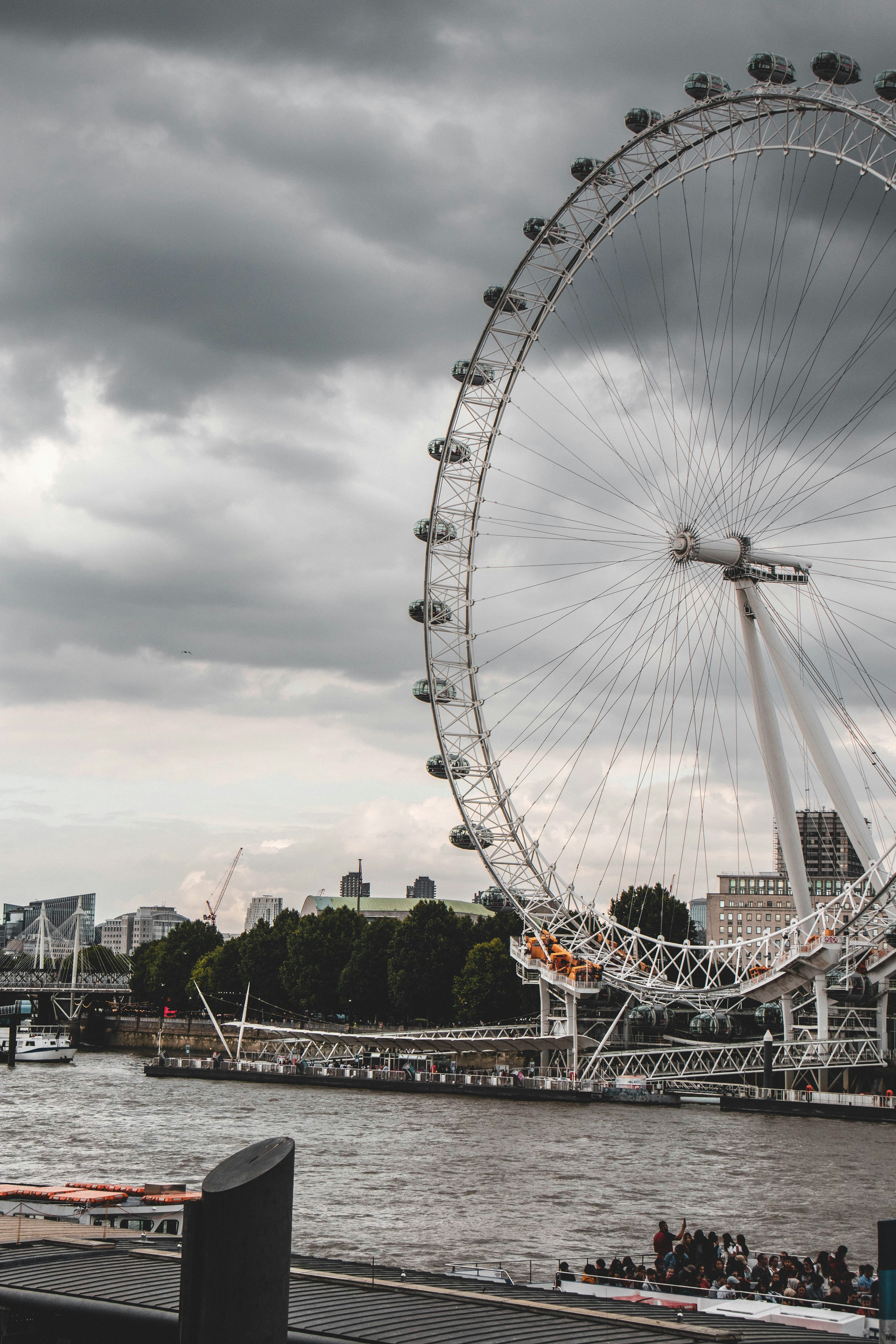 Une grande roue au bord d’une rivière avec le London Eye en arrière ...