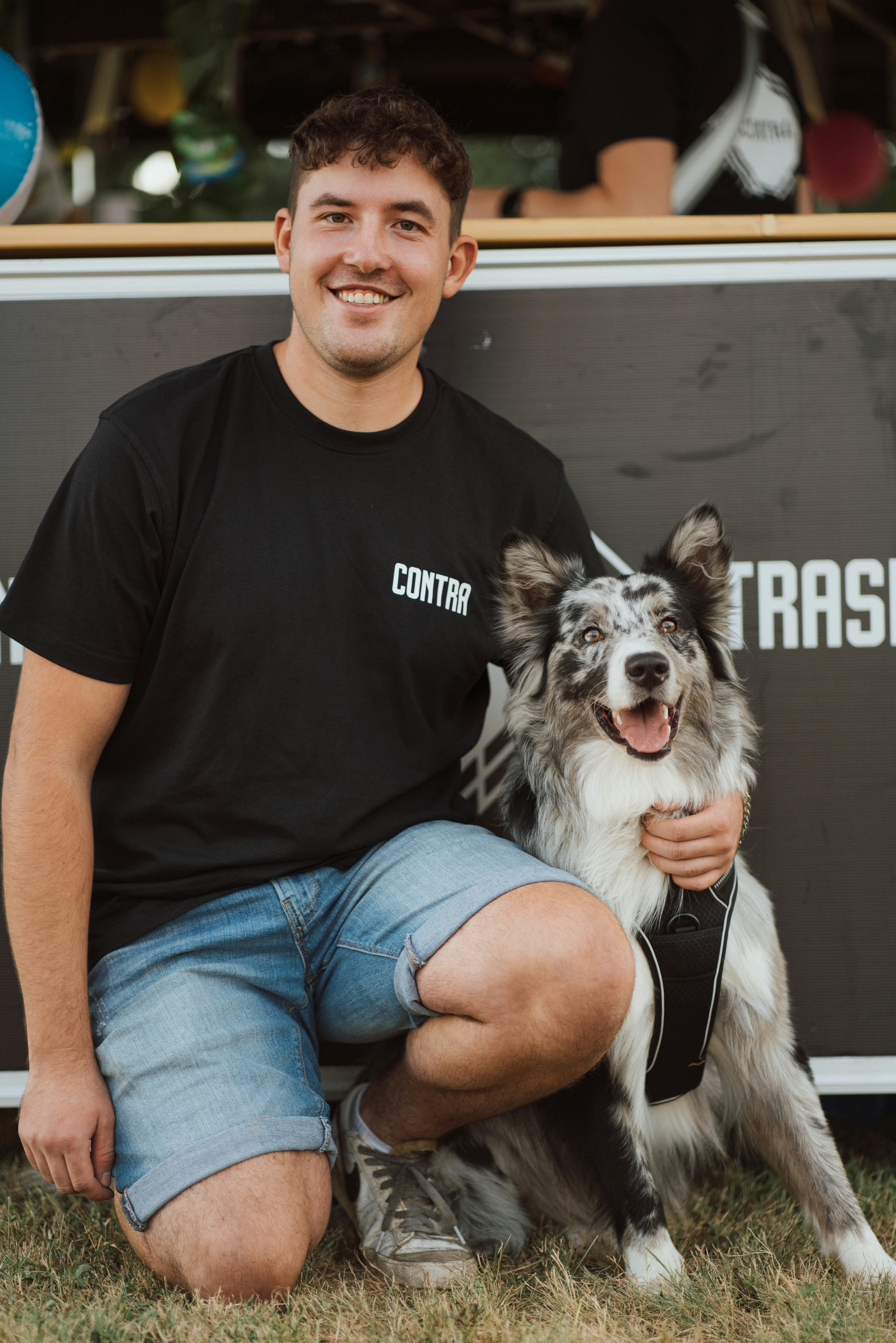 Cheerful Companionship: A Man and His Australian Shepherd at the Edge of a Banner