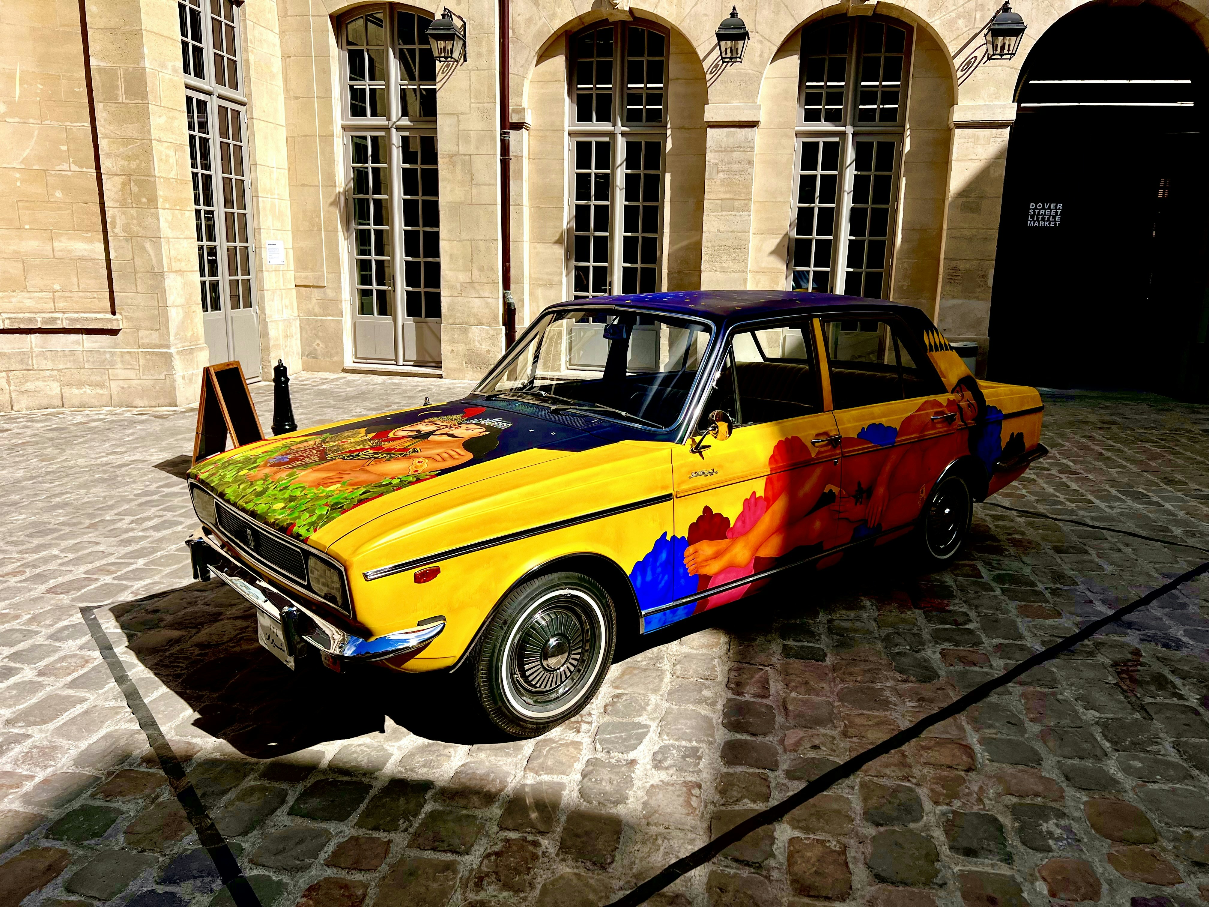 Palette on Wheels: A Painted Classic Under Sunlit Arches