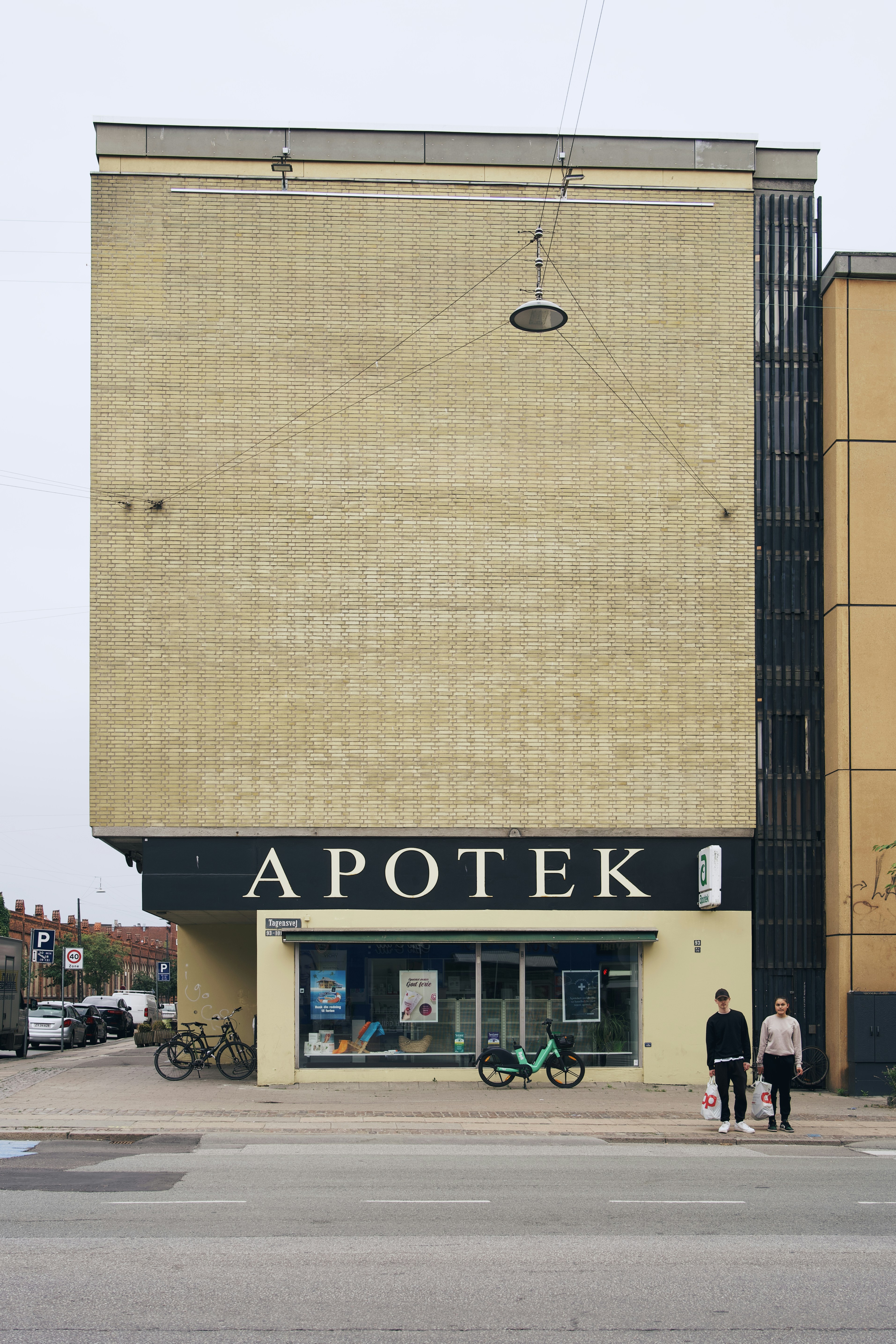 APOTEK on a Brick-Block Stage: Street-Front Symmetry and Quiet Movement