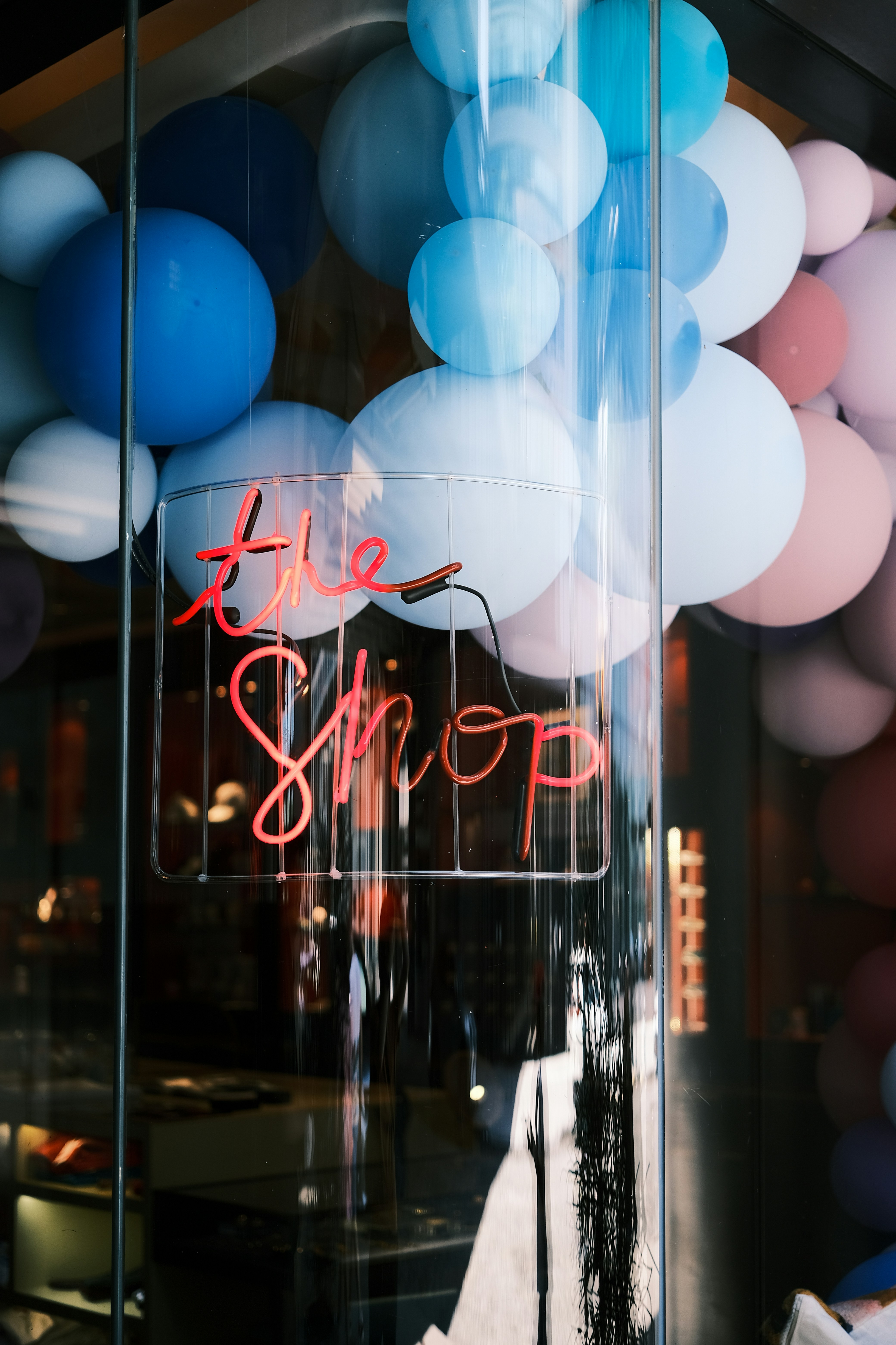 Pastel Balloon Cascade Framing a Red Neon Sign