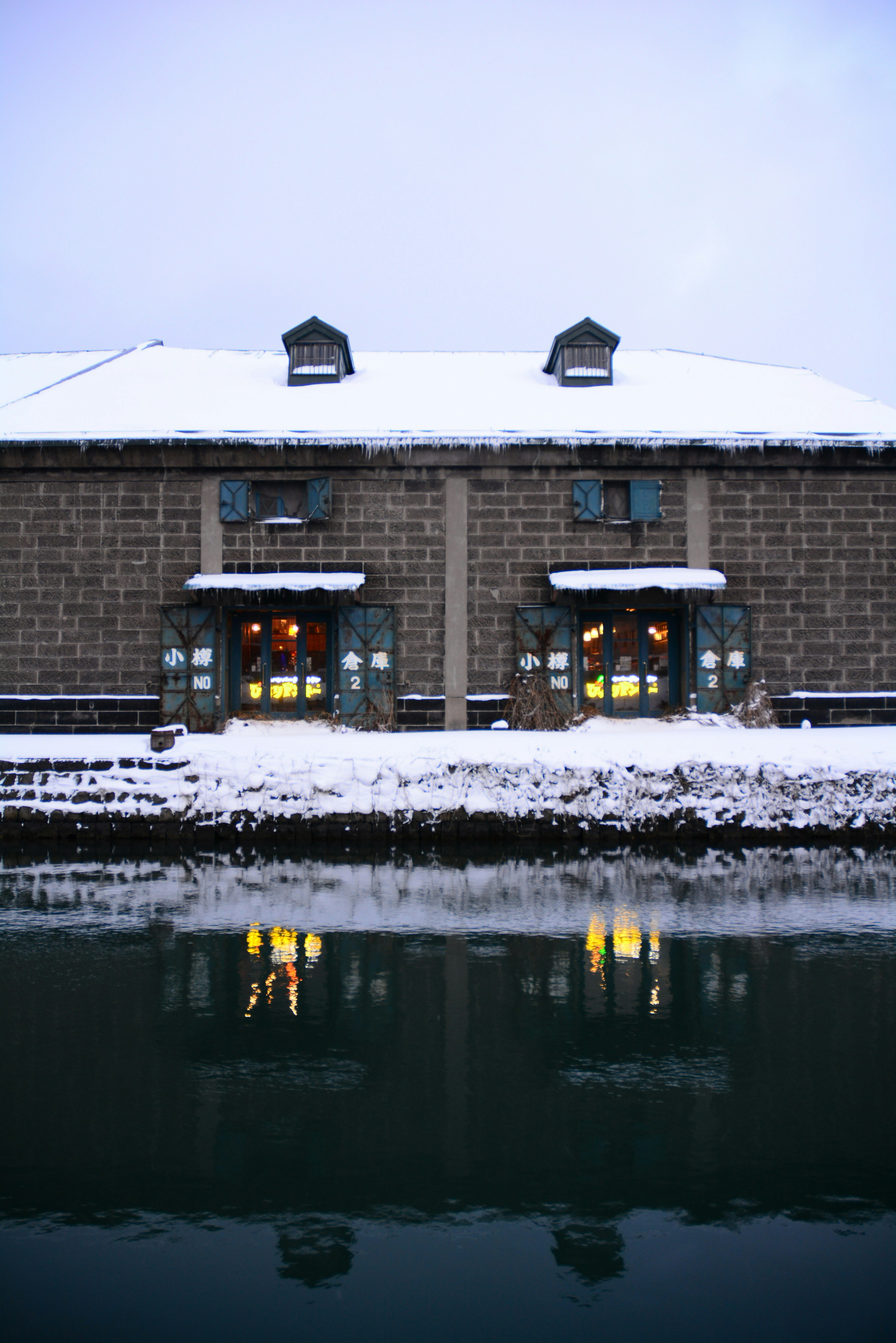 a building with a glass front and a pond in front of it
