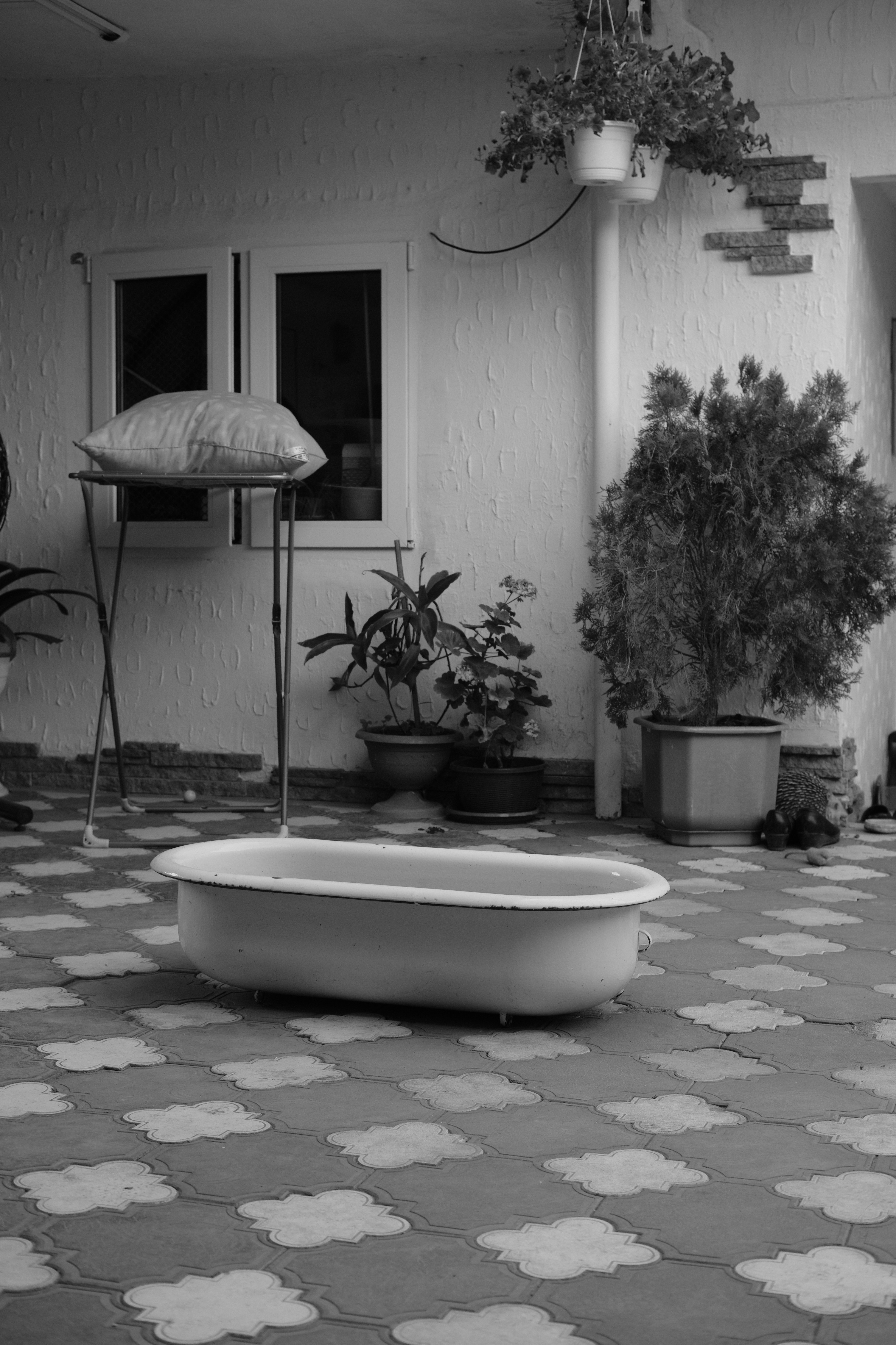 Quiet Geometry: A White Bathtub Anchors a Tile-Patterned Courtyard