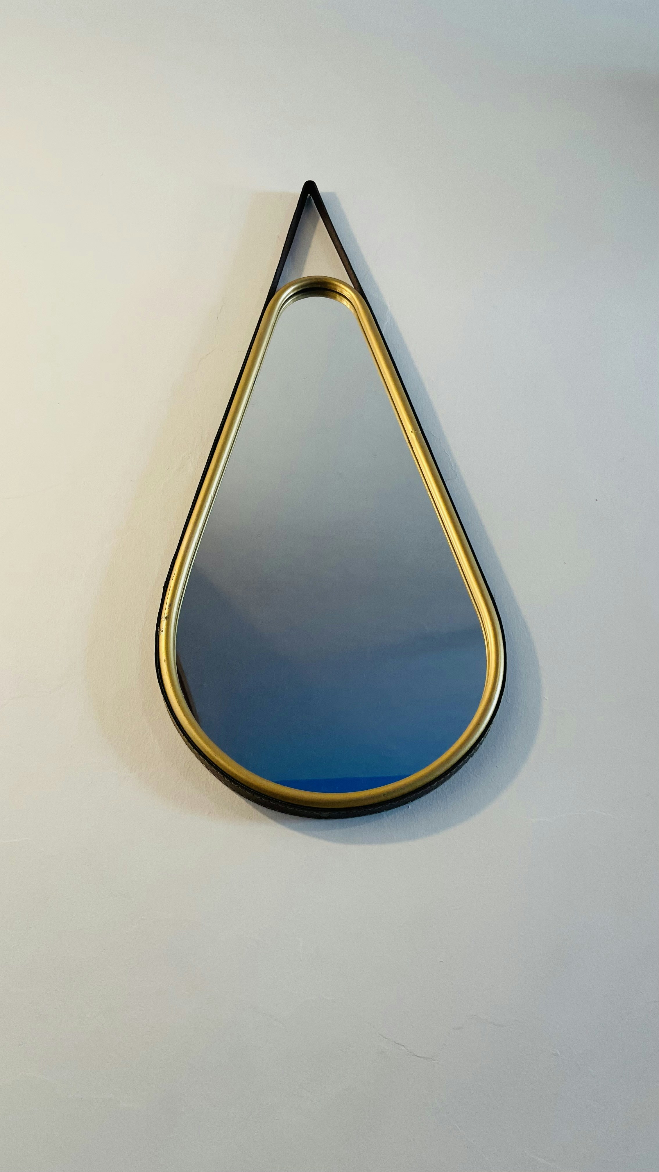 Liquid Gold Mirror: A Teardrop Shape Framed by Soft Wall Light