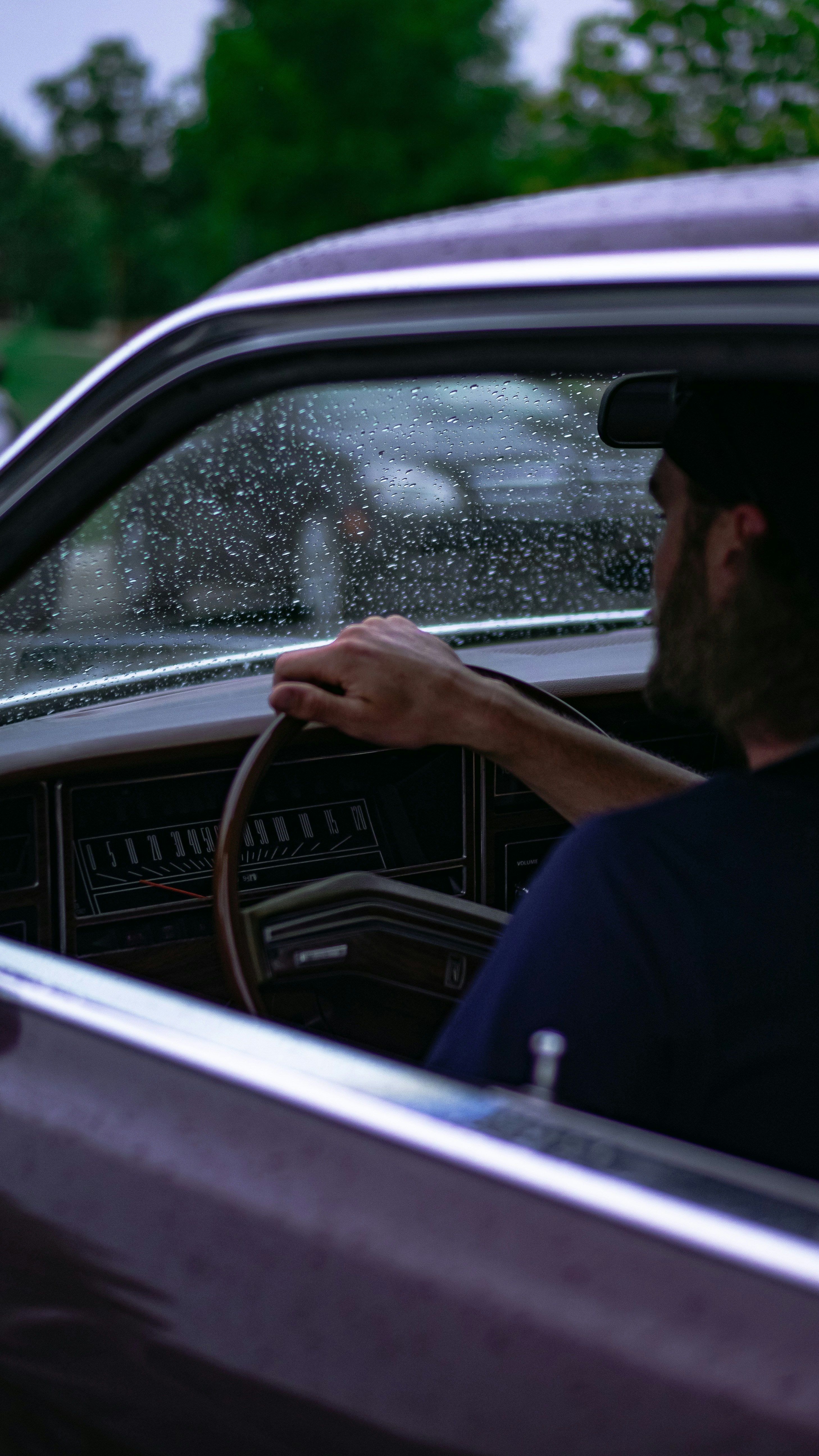 Rain on Chrome: A Quiet Moment Behind the Wheel of a Vintage Car