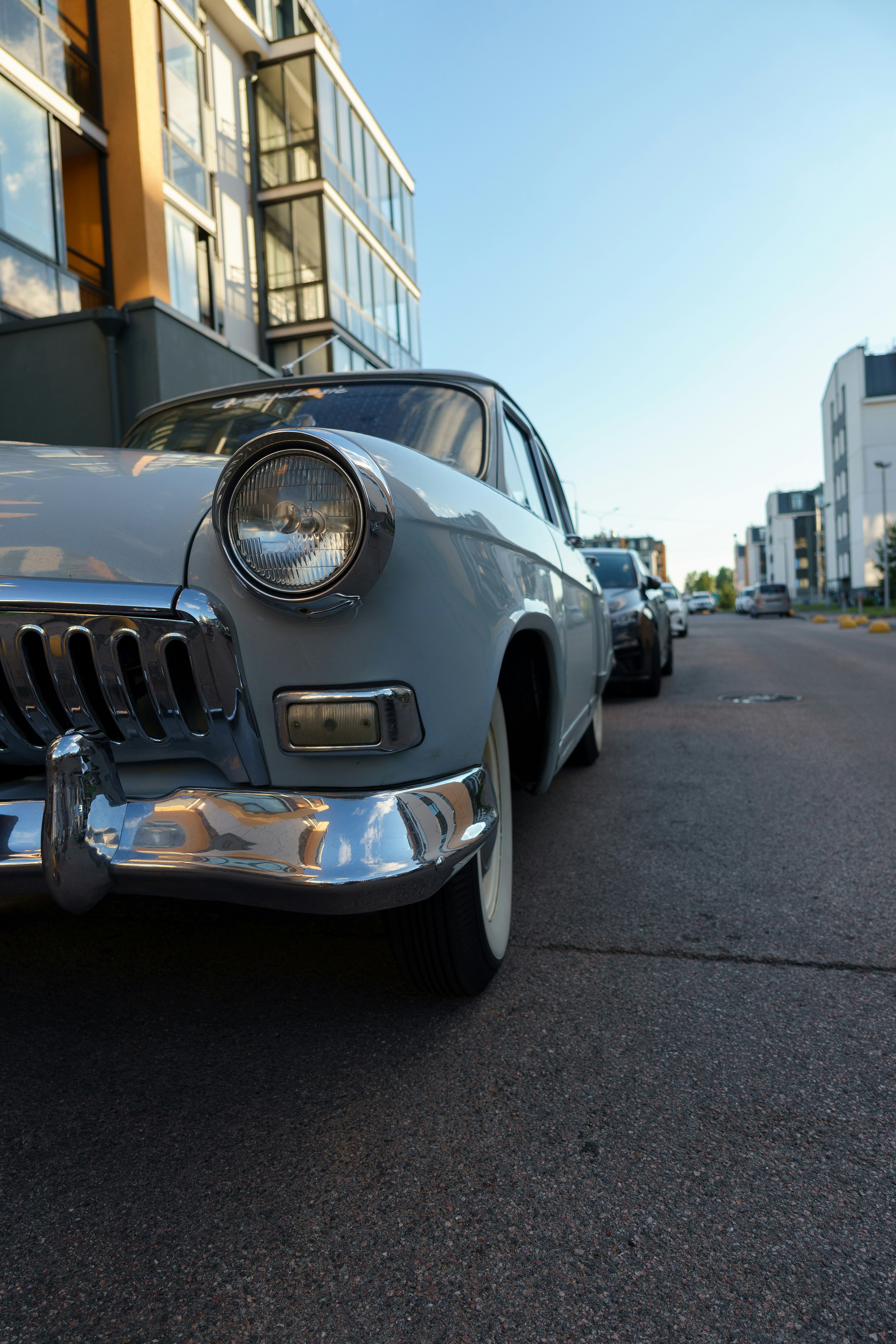 Chrome Echo on Asphalt: A Vintage Sedan Anchors a Modern Street