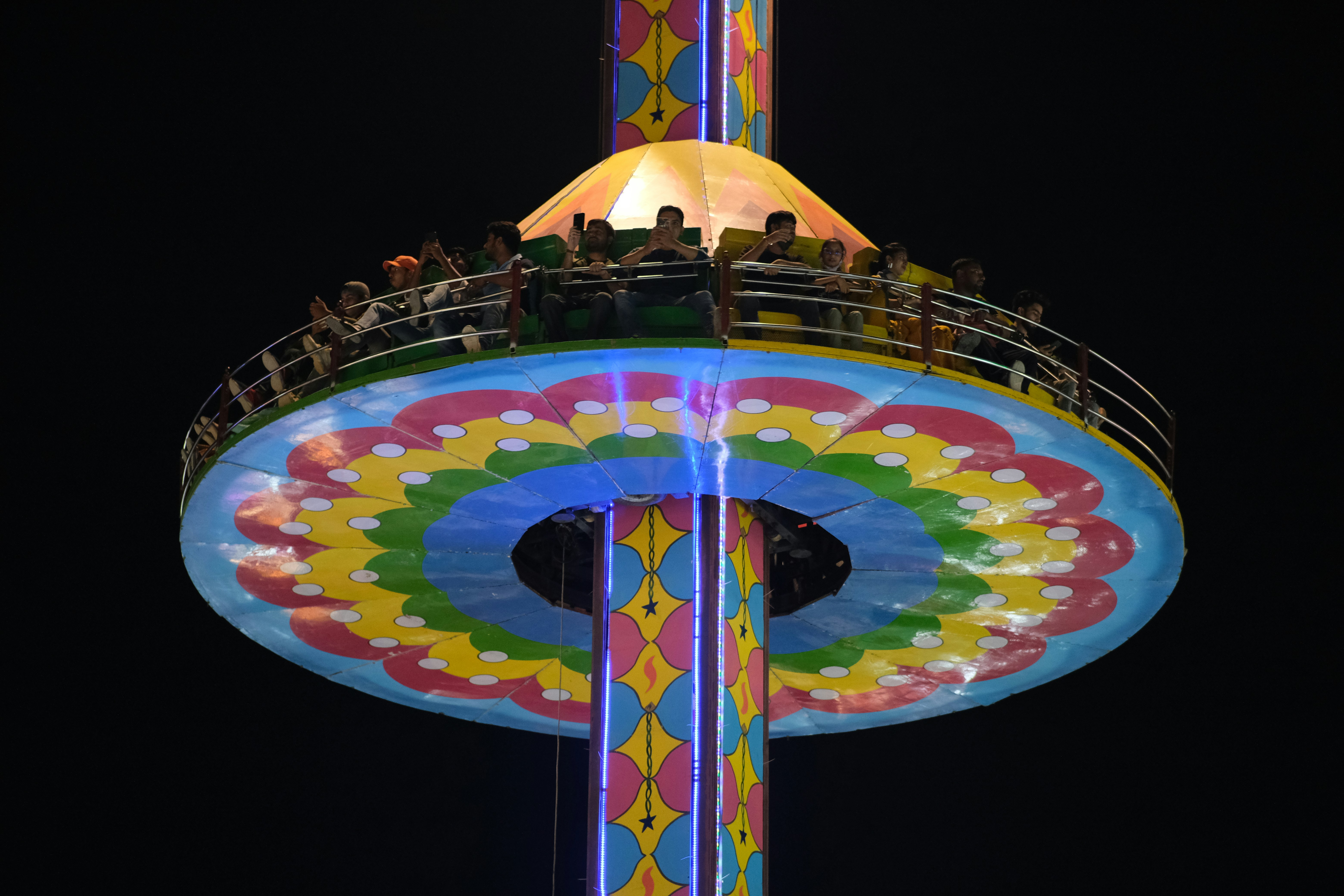 Colorful amusement ride spinning against a dark night sky.