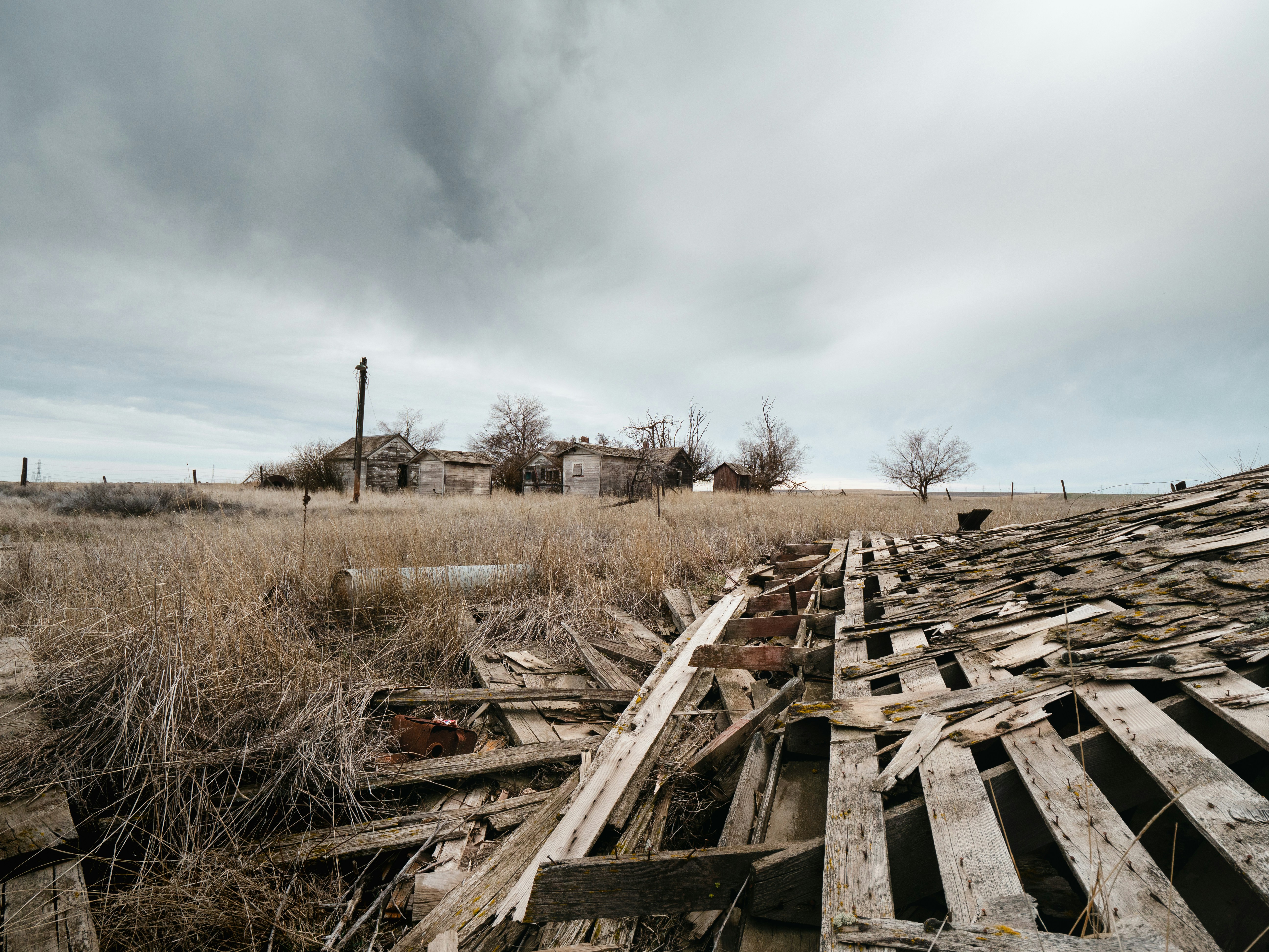 A field with a fence and a house in the distance photo – Free ...