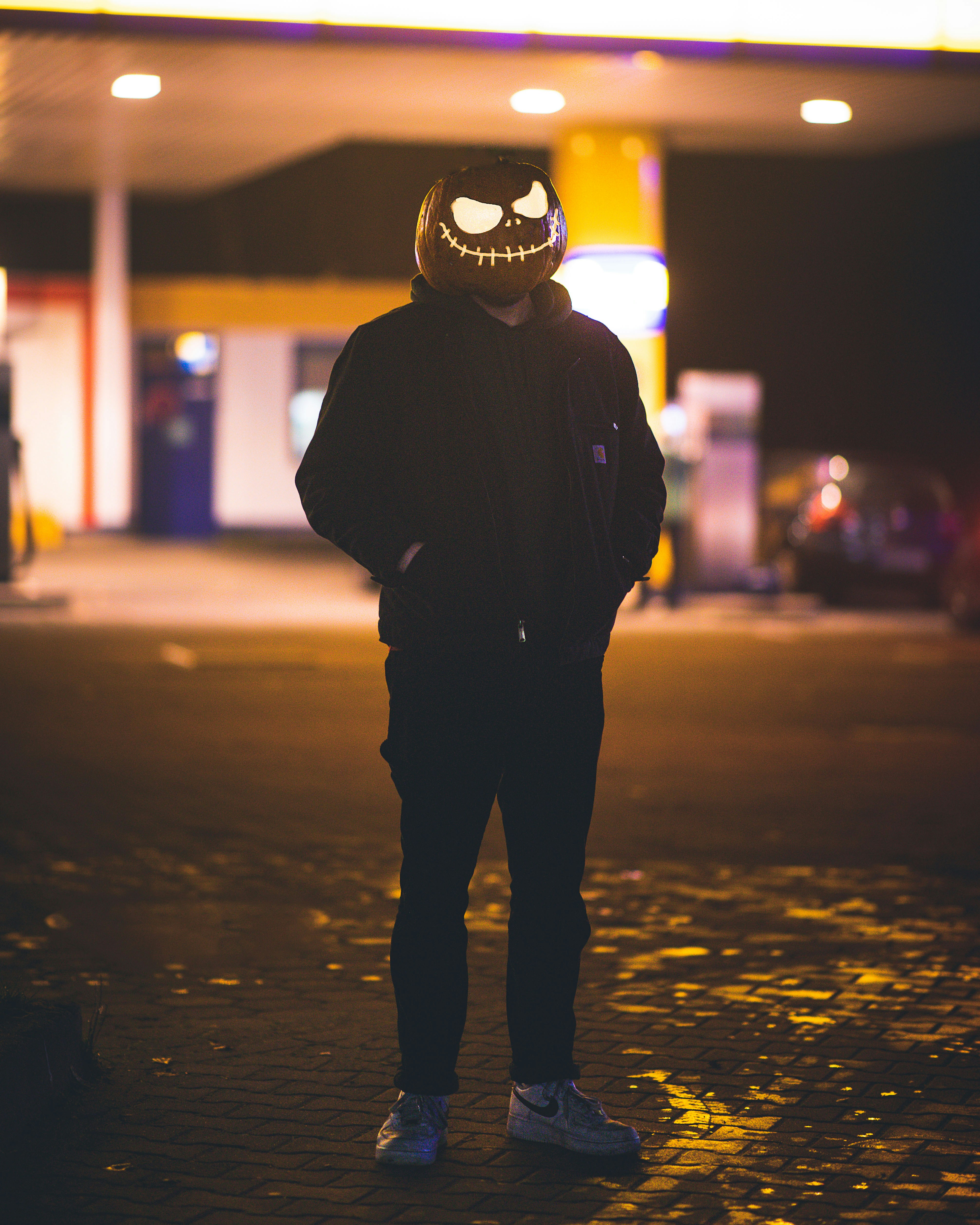 Masked Wanderer Under Neon Night at the Gas Station