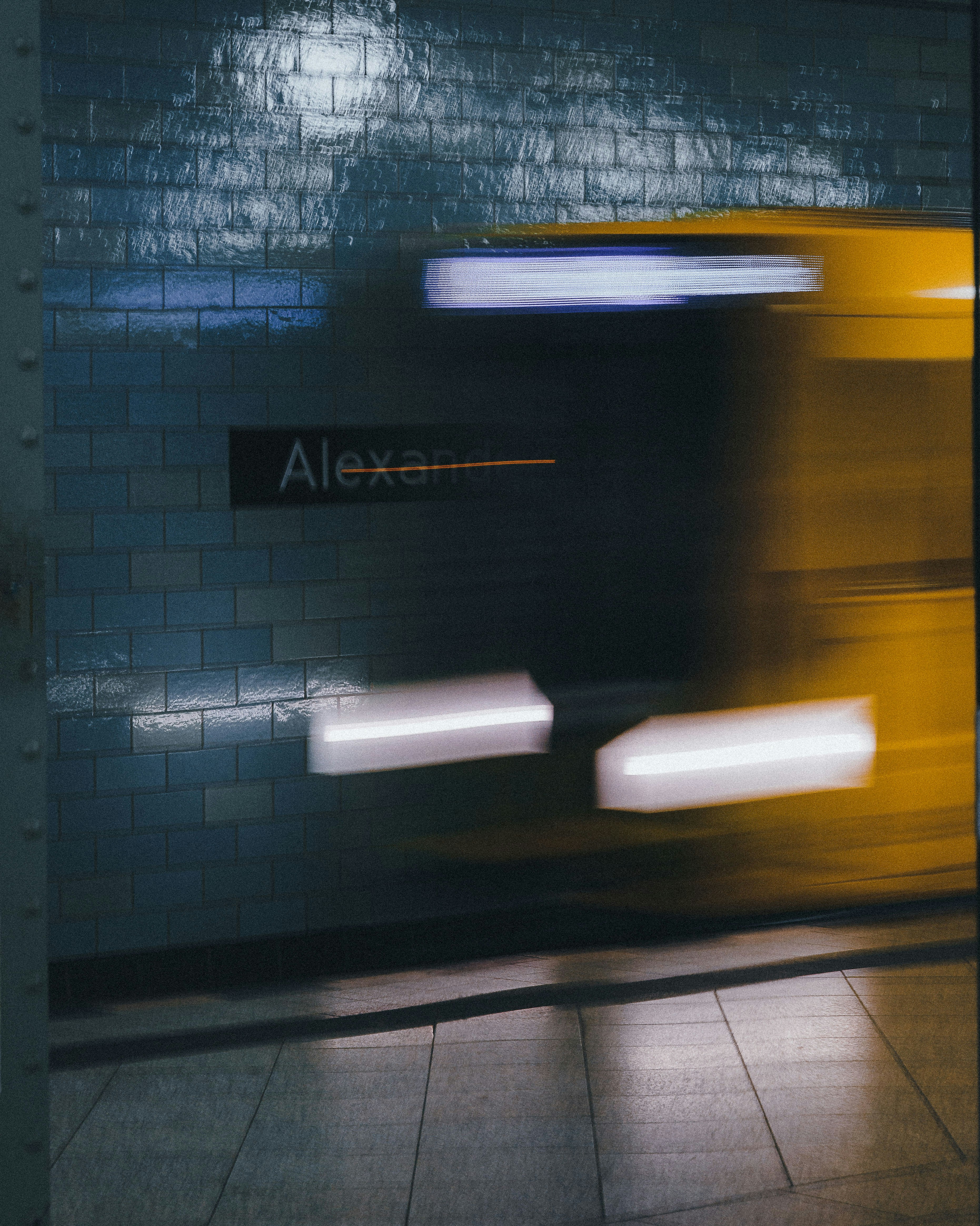 Electric Blur: Yellow Train Slices Through a Blue Tile Subway Wall