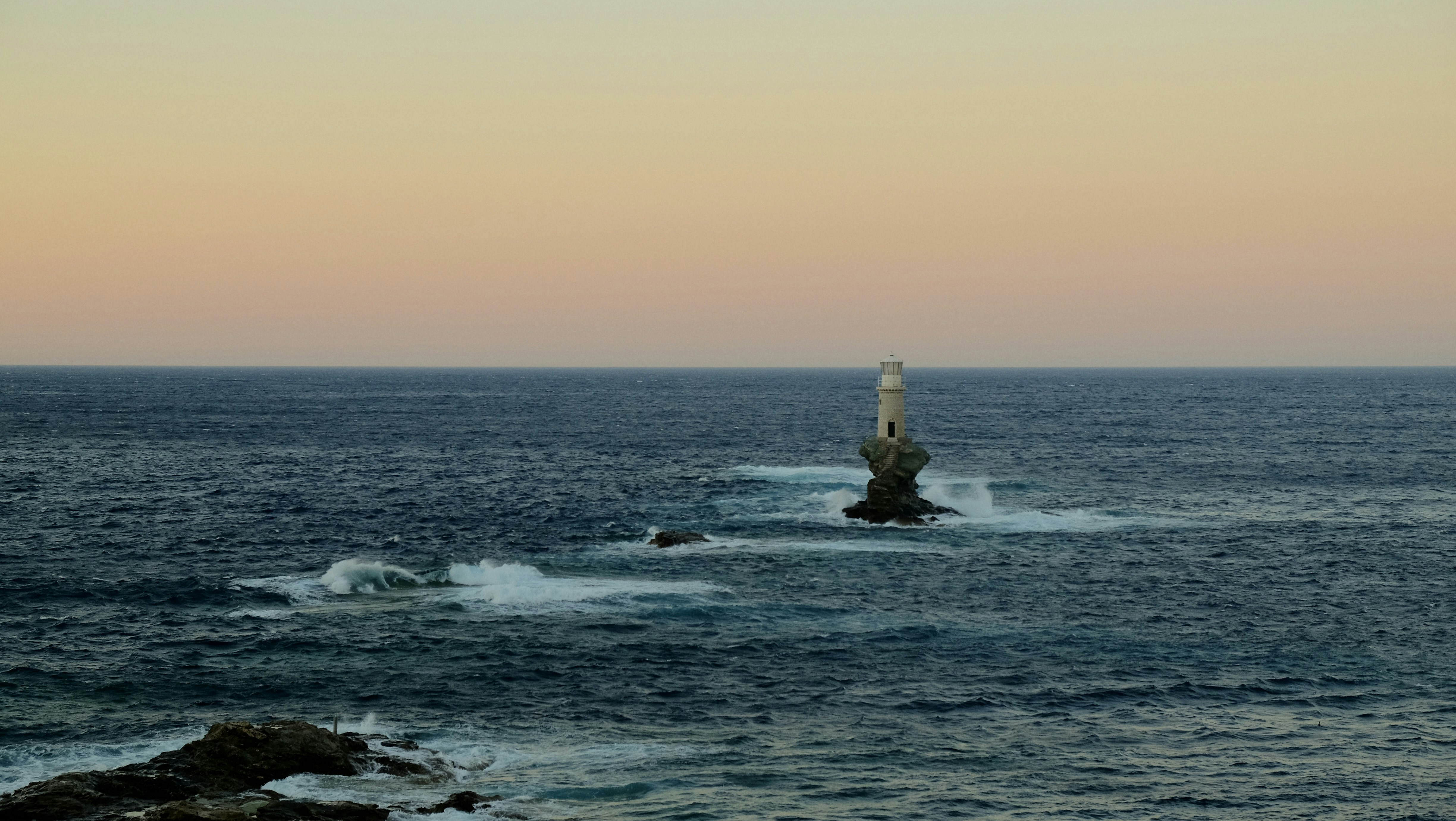 A lighthouse in the middle of the ocean photo – Free Sea Image on Unsplash