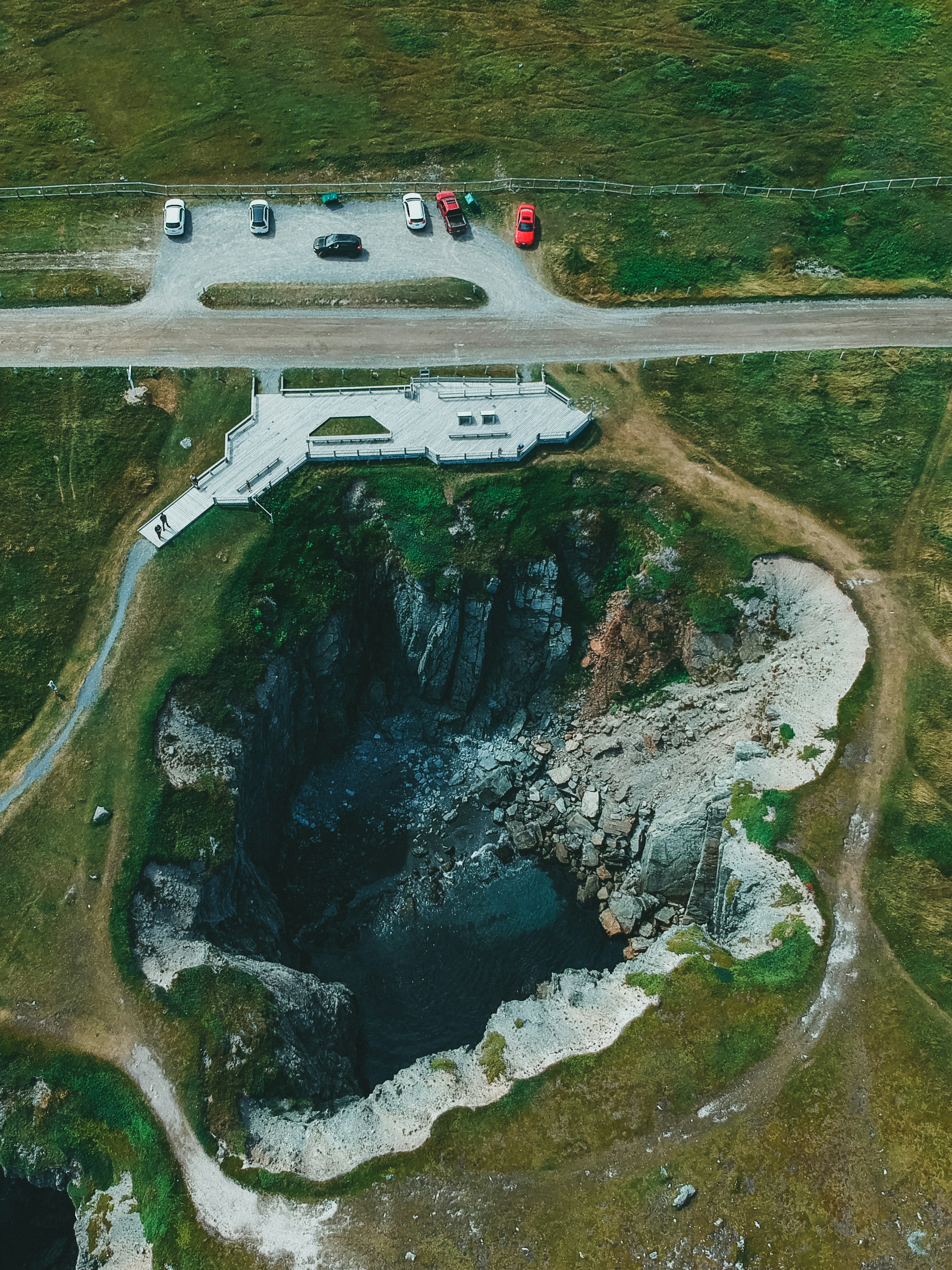 Cliffside Crater: A Drone View Over Rock, Walkway, and the Dark Basin