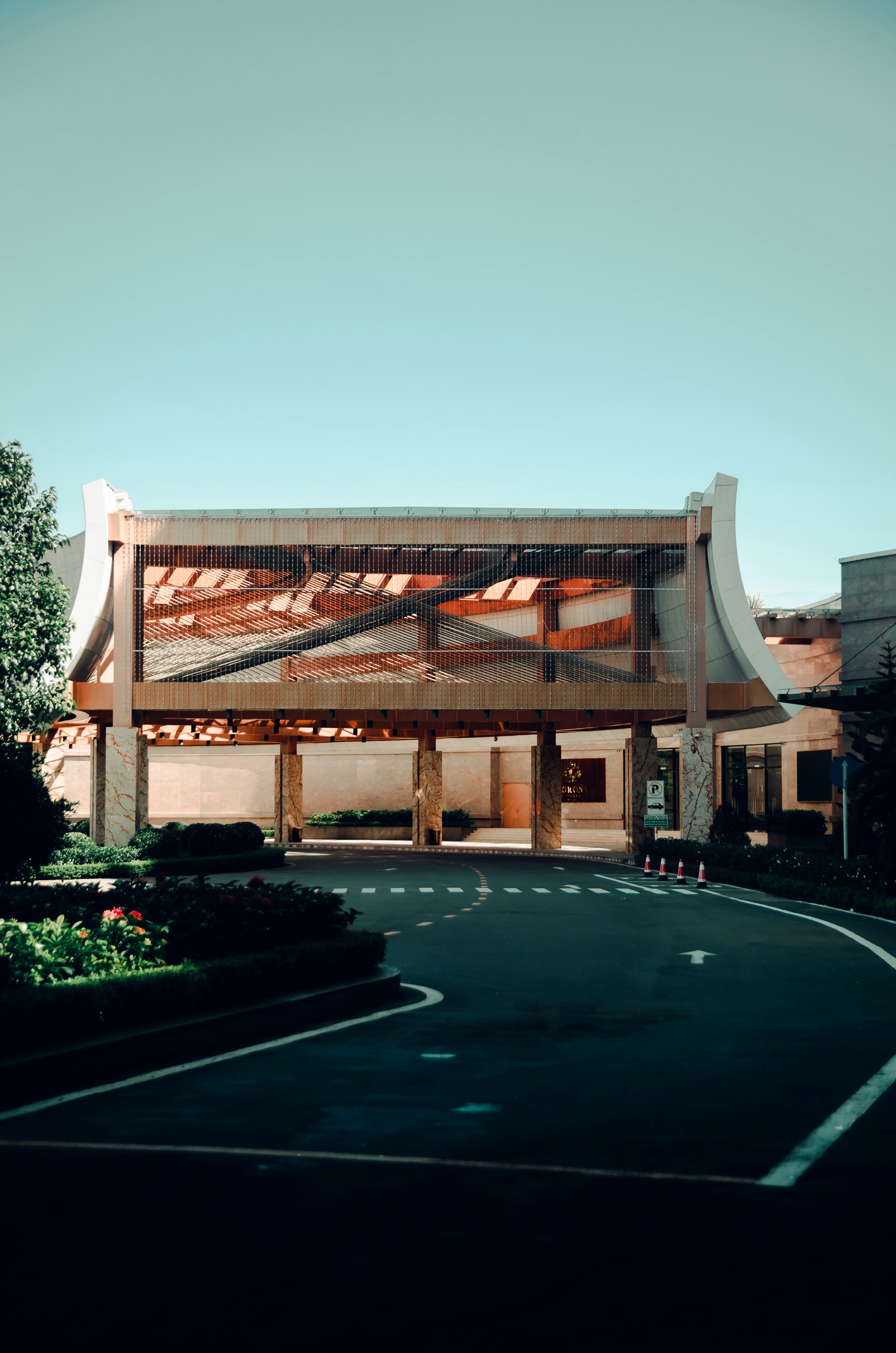 Contemporary building facade with a peaked roof and open wooden beams under a clear sky.