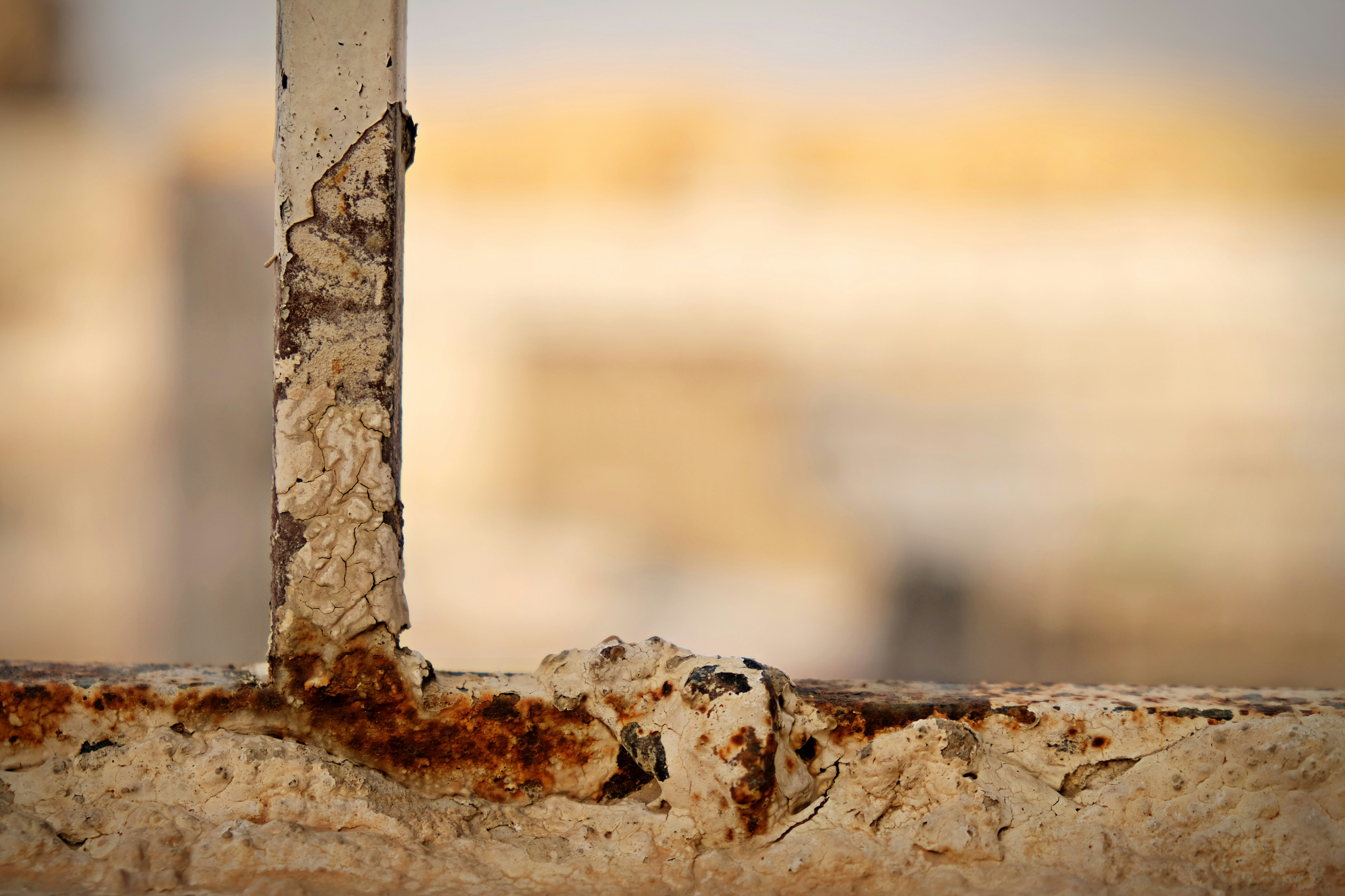 Rust and Light: Cracked Bar and Crumbling Concrete Close-Up