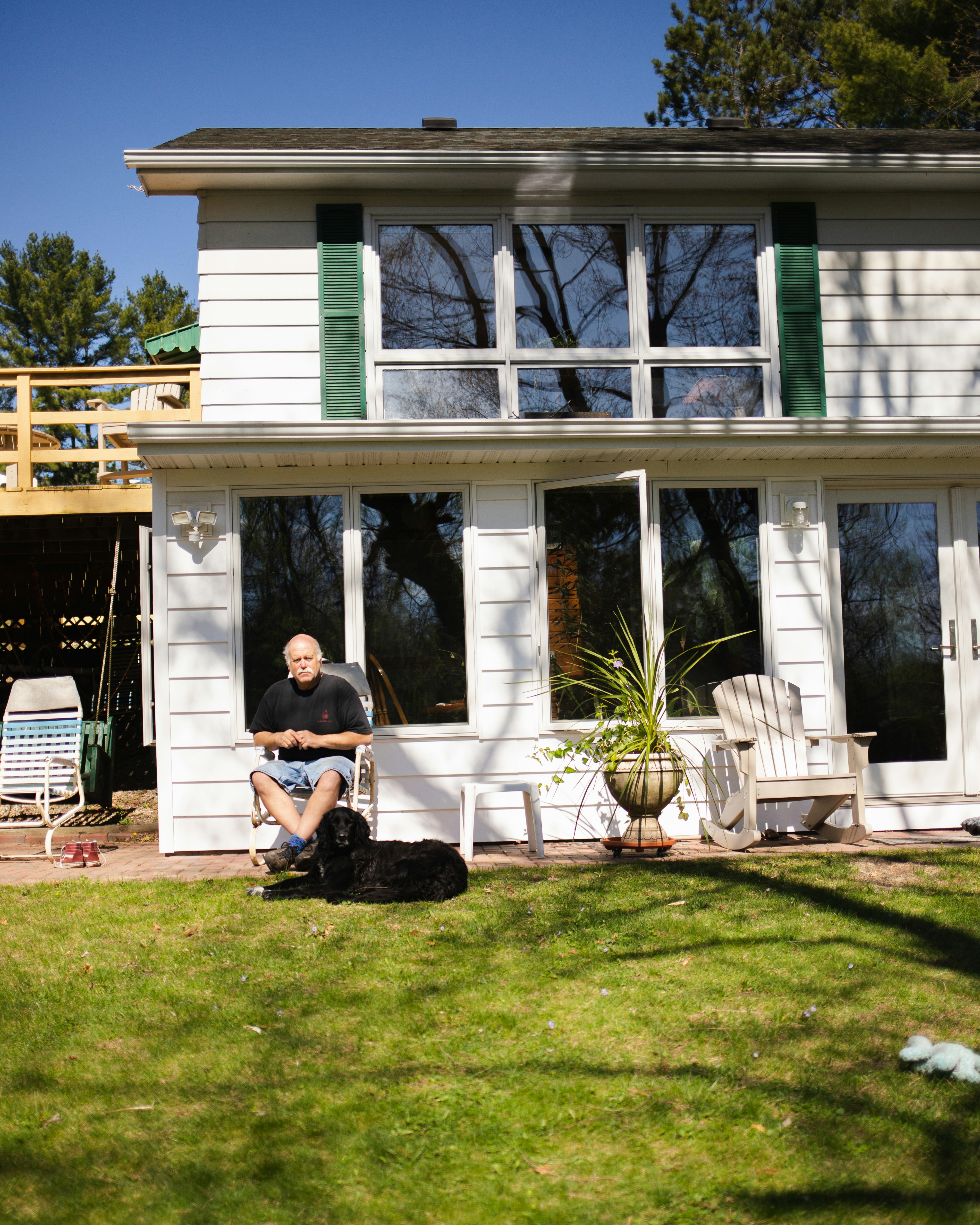 Une personne assise sur une chaise de jardin devant une maison photo ...