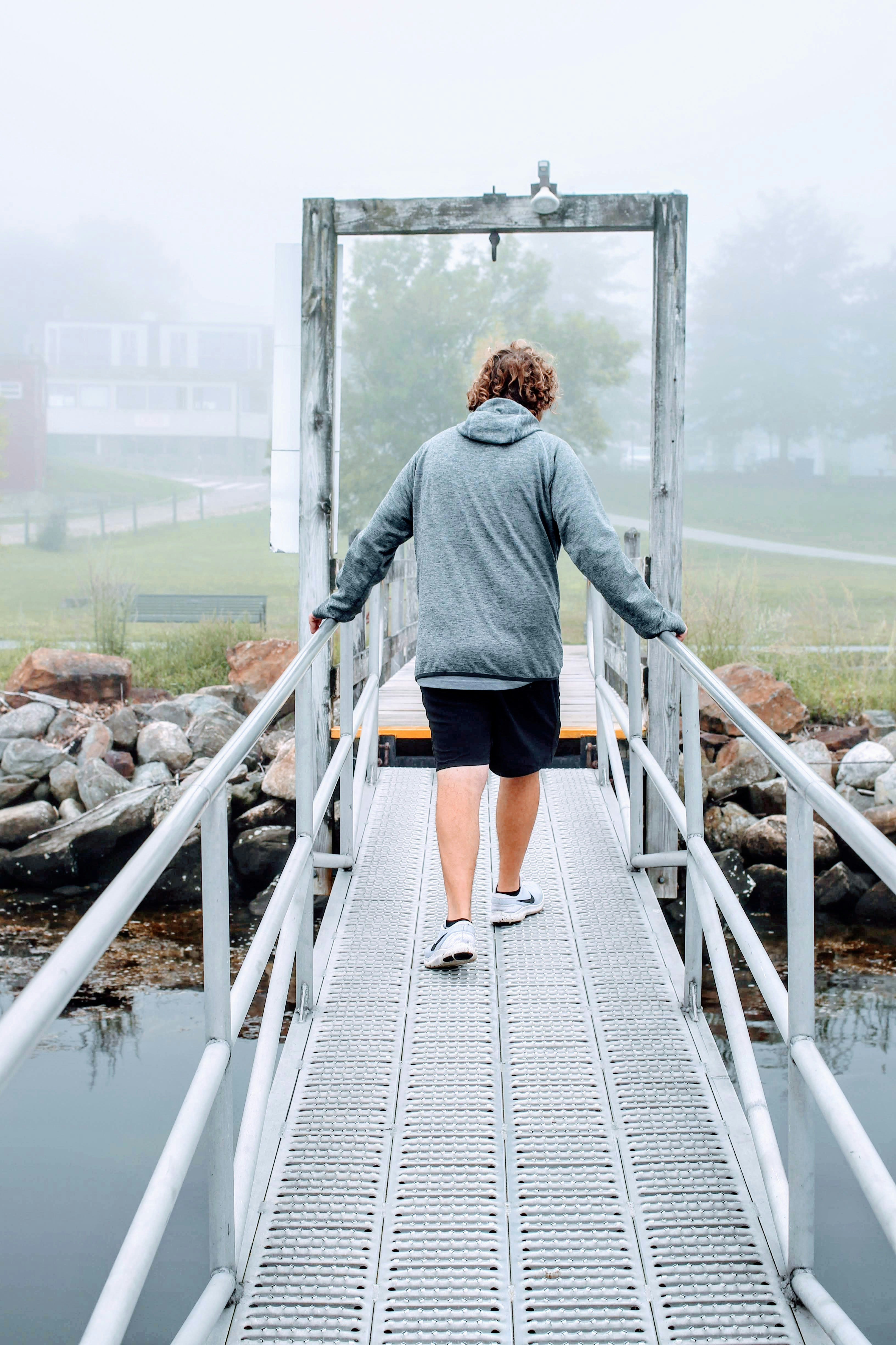 Traveler on a Misty Dock: A Quiet Walk Toward a Framed Horizon