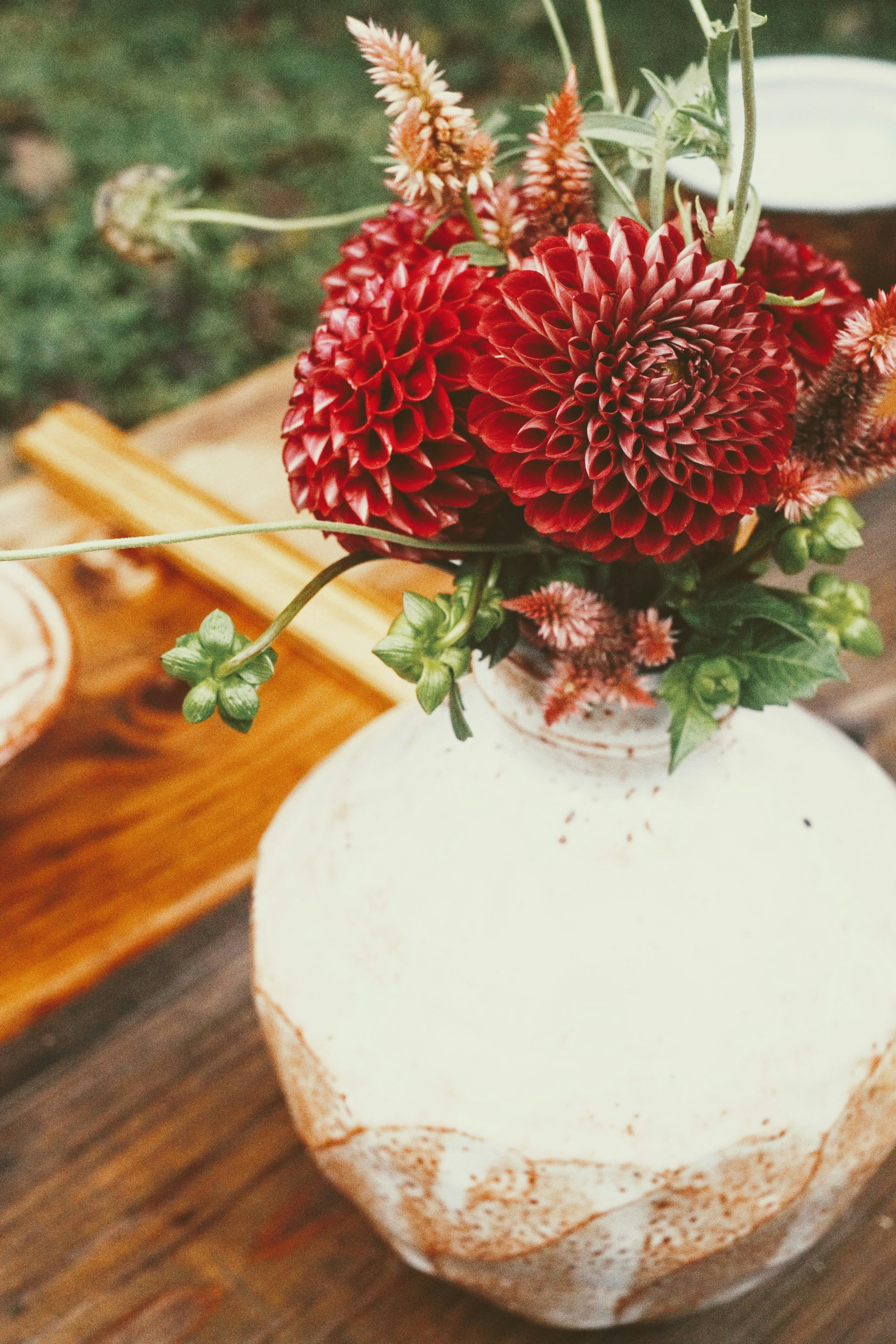 Crimson Dahlias in a Rustic Ceramic Vase