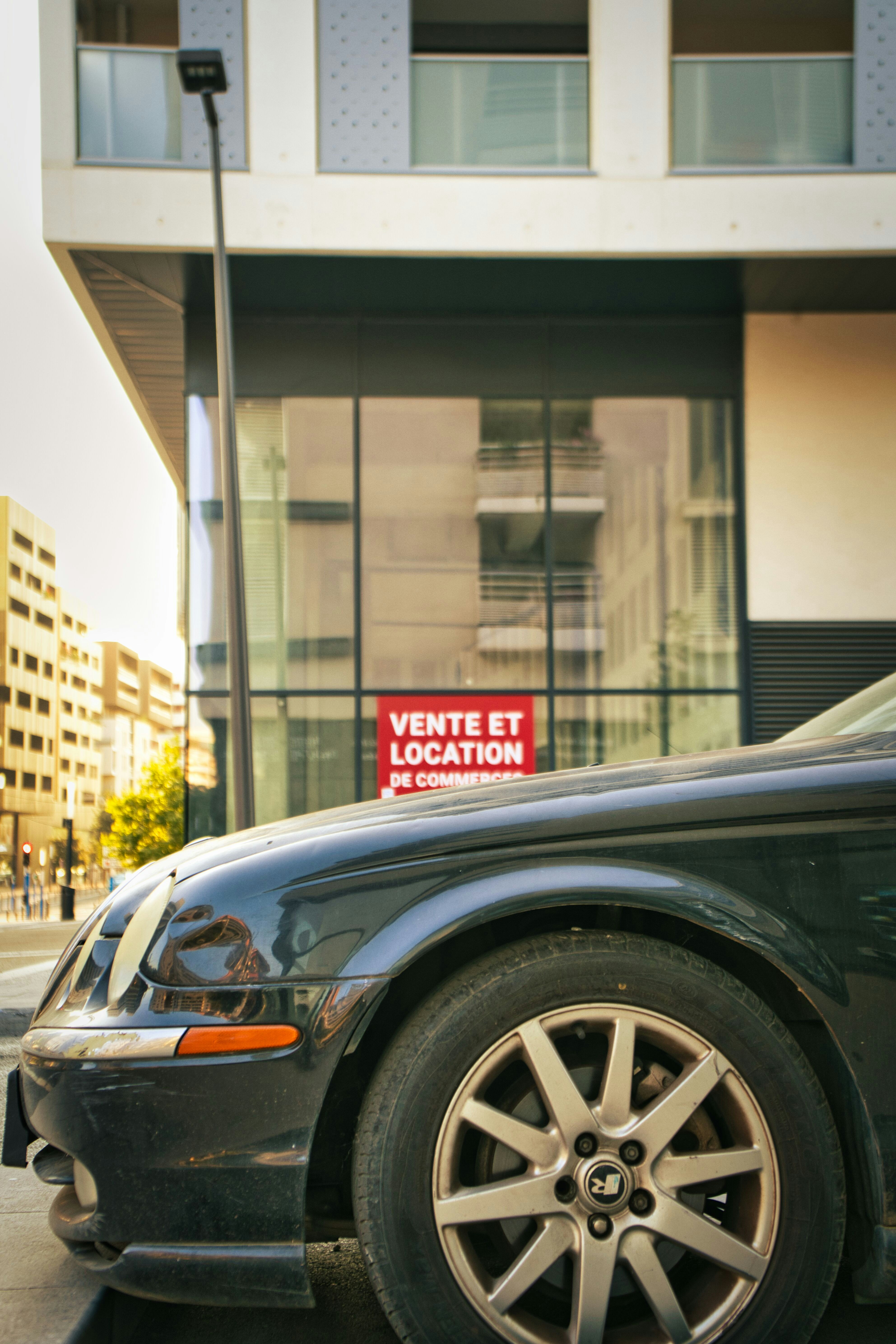 Chrome Wheel and Urban Facade: A Street-Level Car Portrait