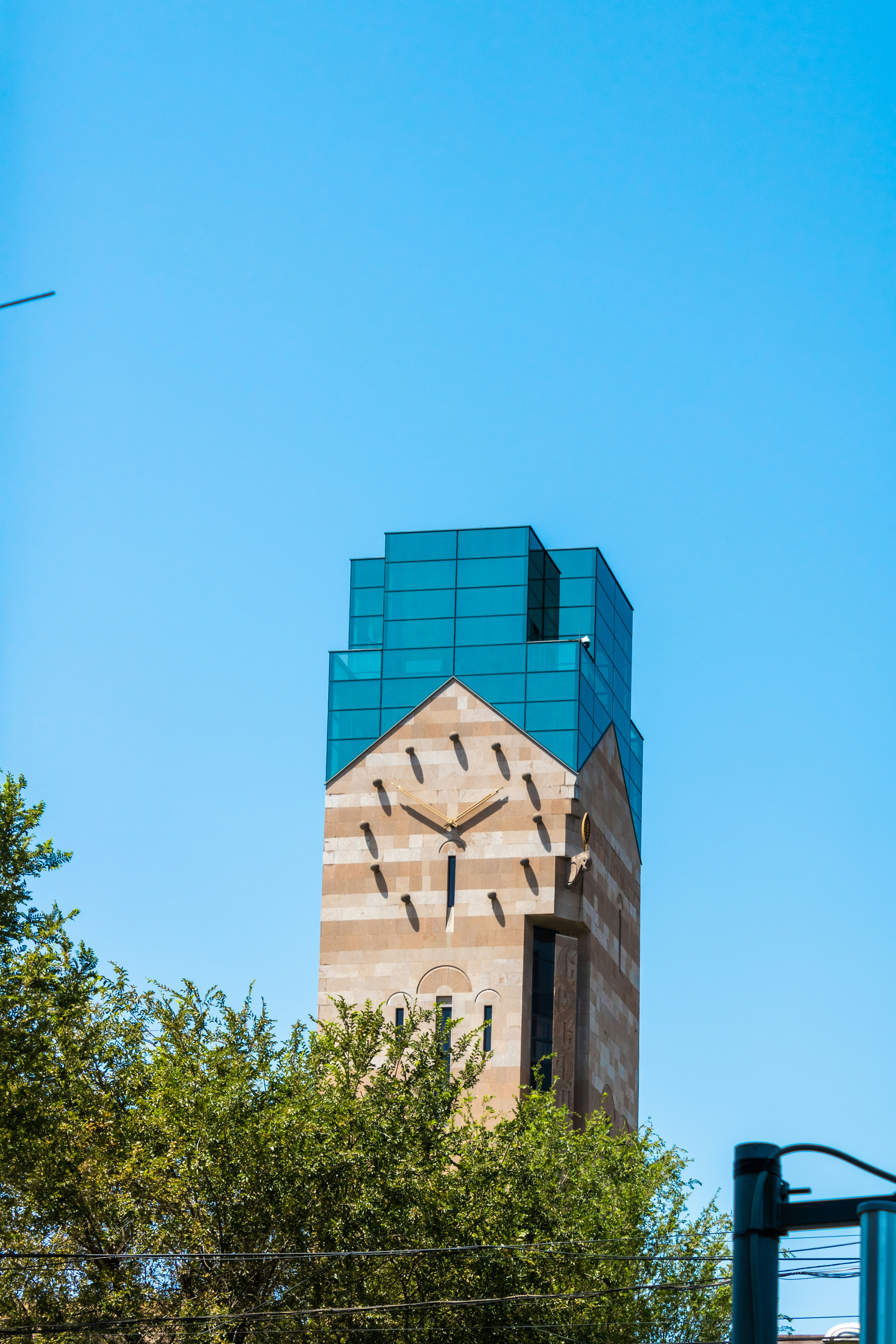 Turquoise Glass Crown Adorns a Brick Clock Tower Under a Pristine Sky
